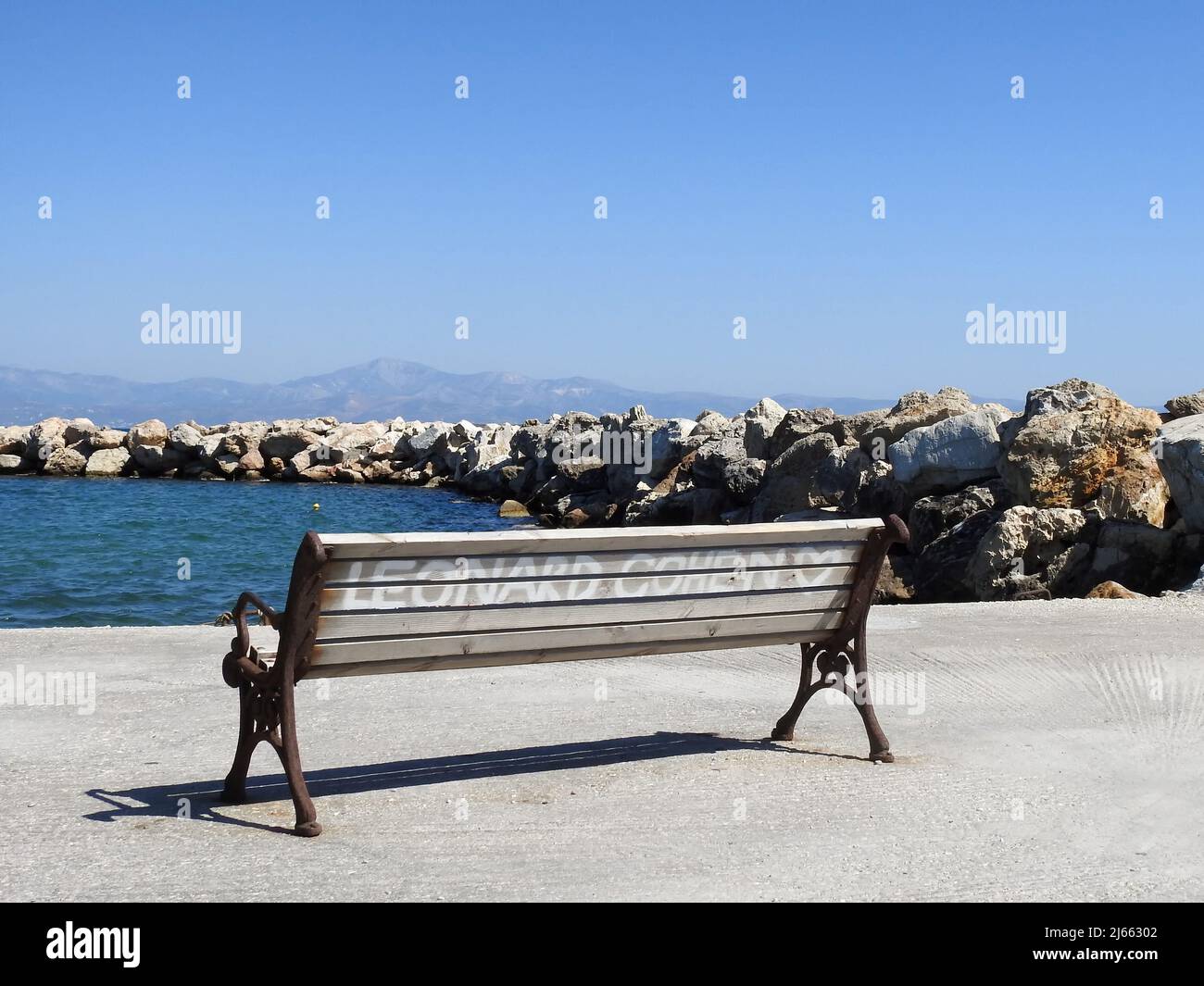 Bench facing the sea with the name leonard Cohen painted on its back ...