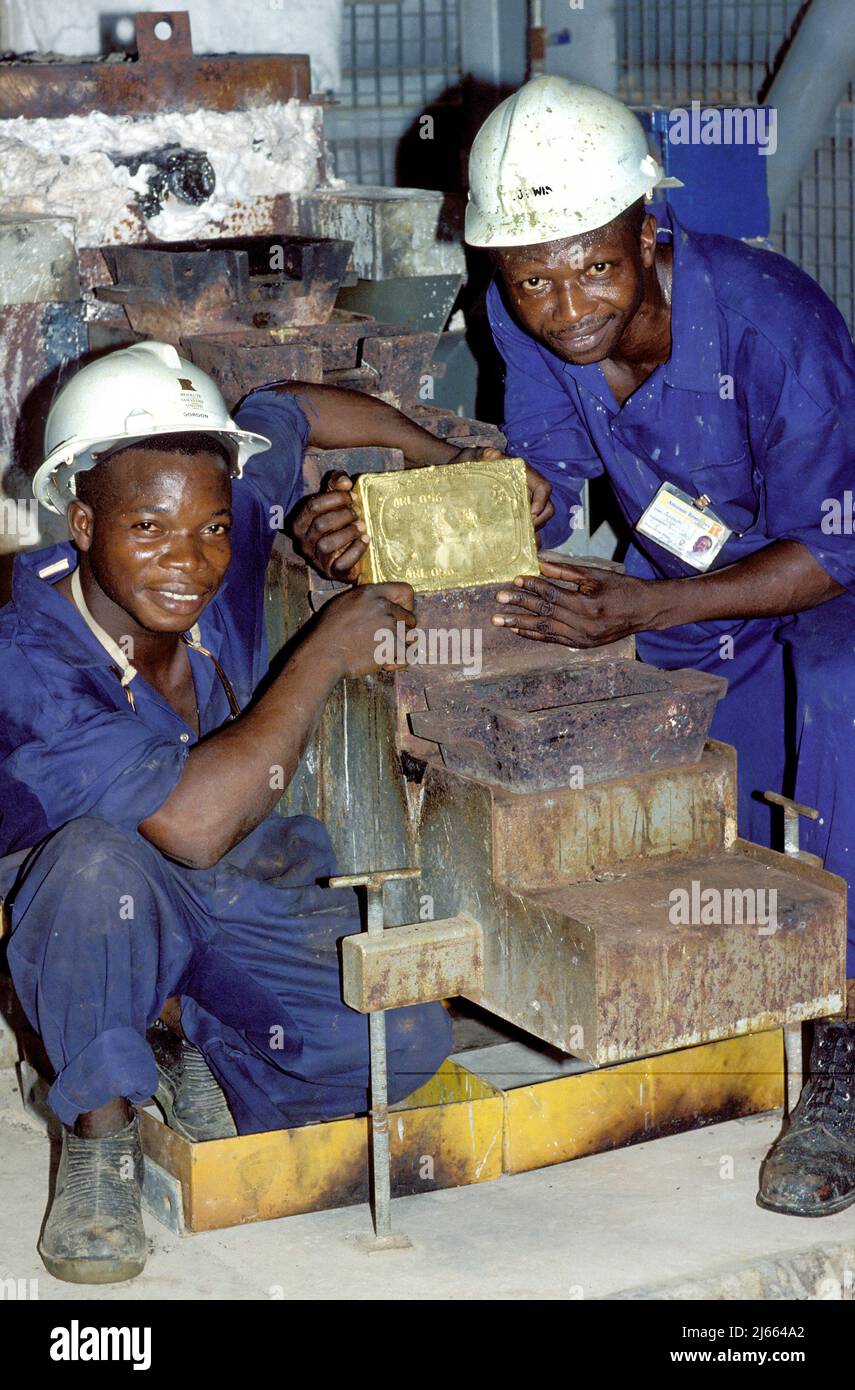 Ghana, Kumasi region; workers showing piece of gold from gold mine ...