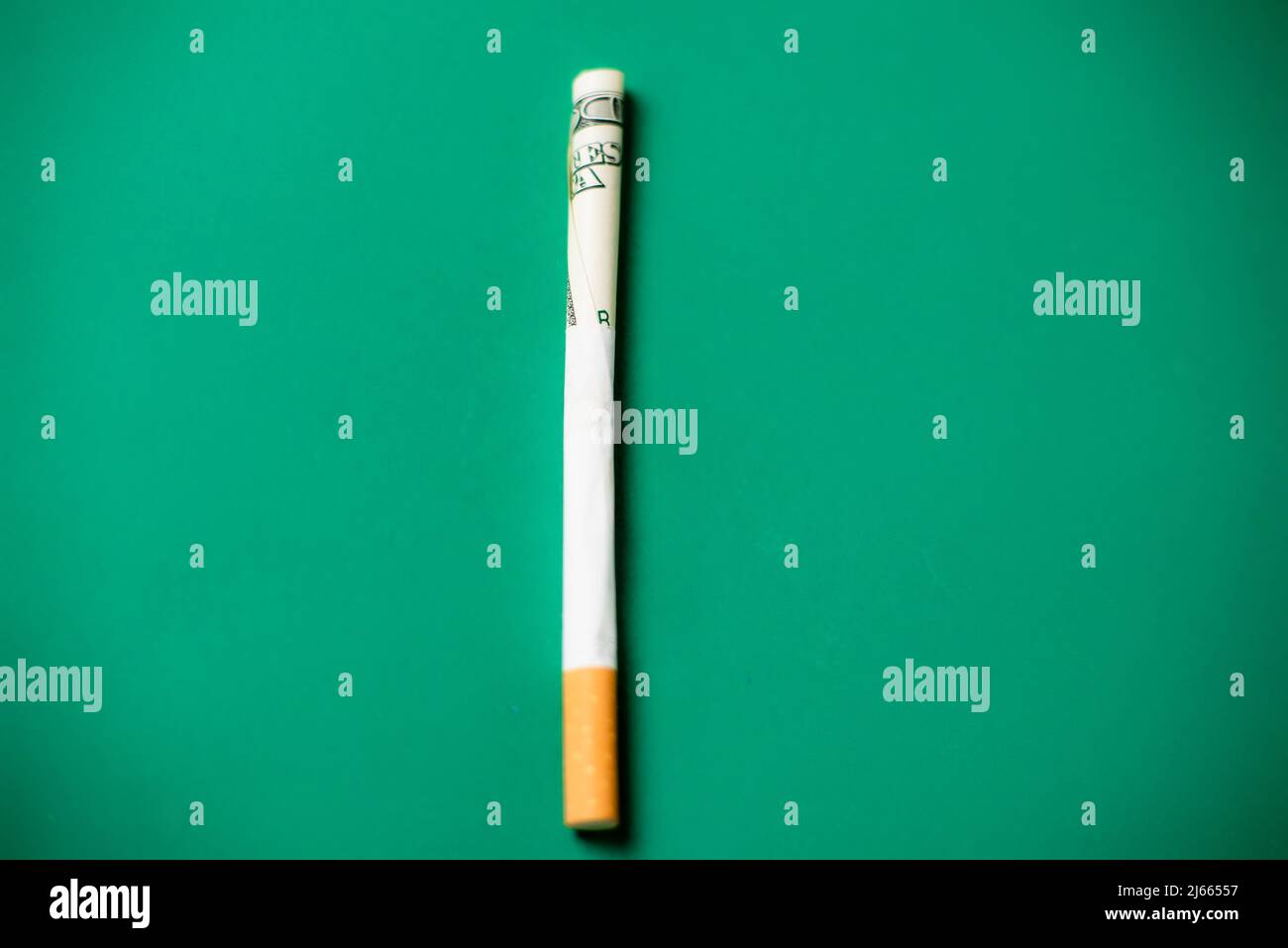 Smoking and money. Rolled up dollar bill in a cigarette. Green ...