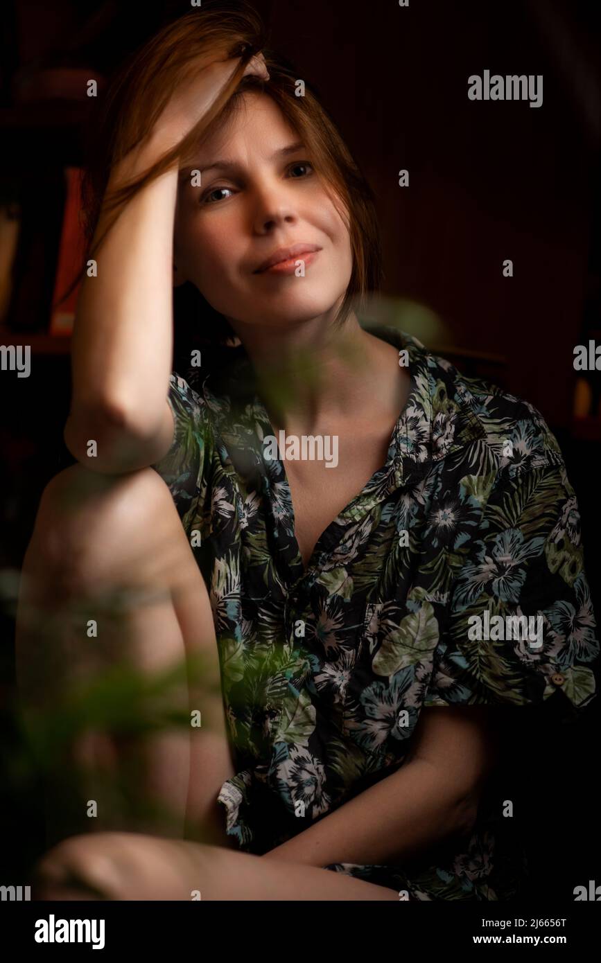 Woman relaxing at home in plants. an attractive woman of forty years of ...
