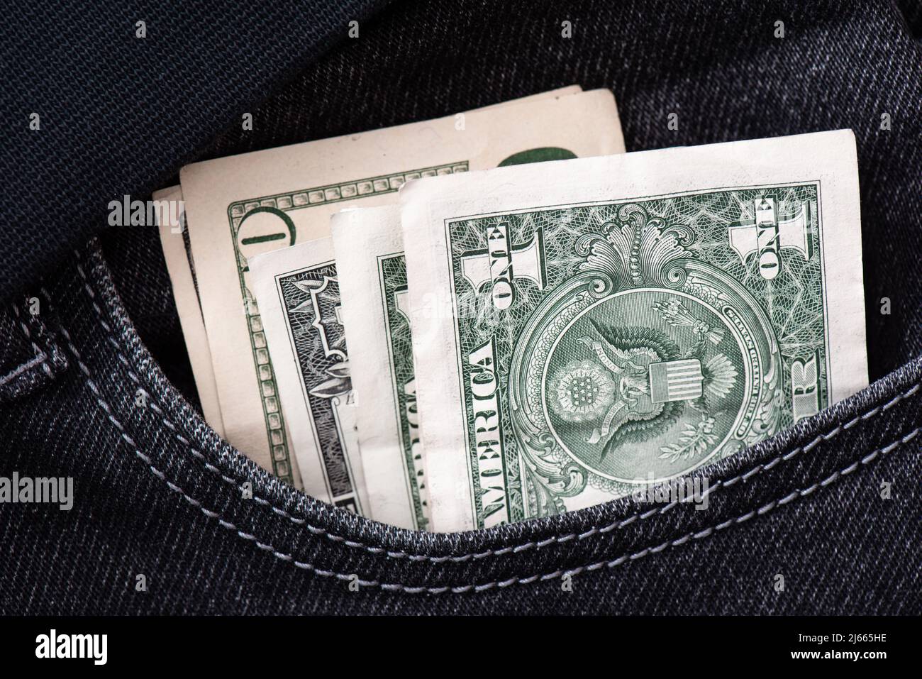 Cash Paper banknotes of US dollars in the pocket of black jeans. Saving ...