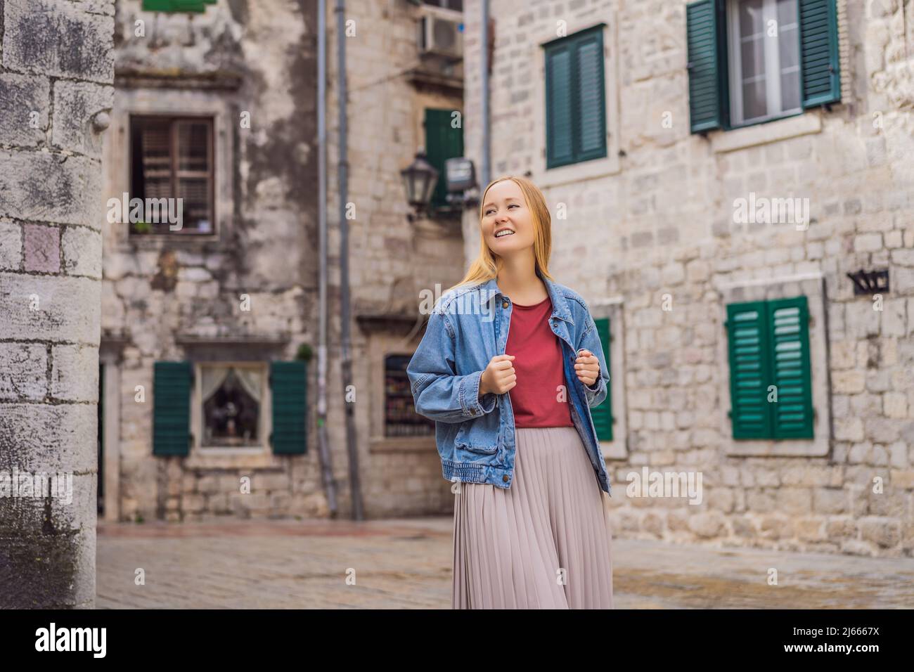 Woman tourist enjoying Colorful street in Old town of Kotor on a sunny ...