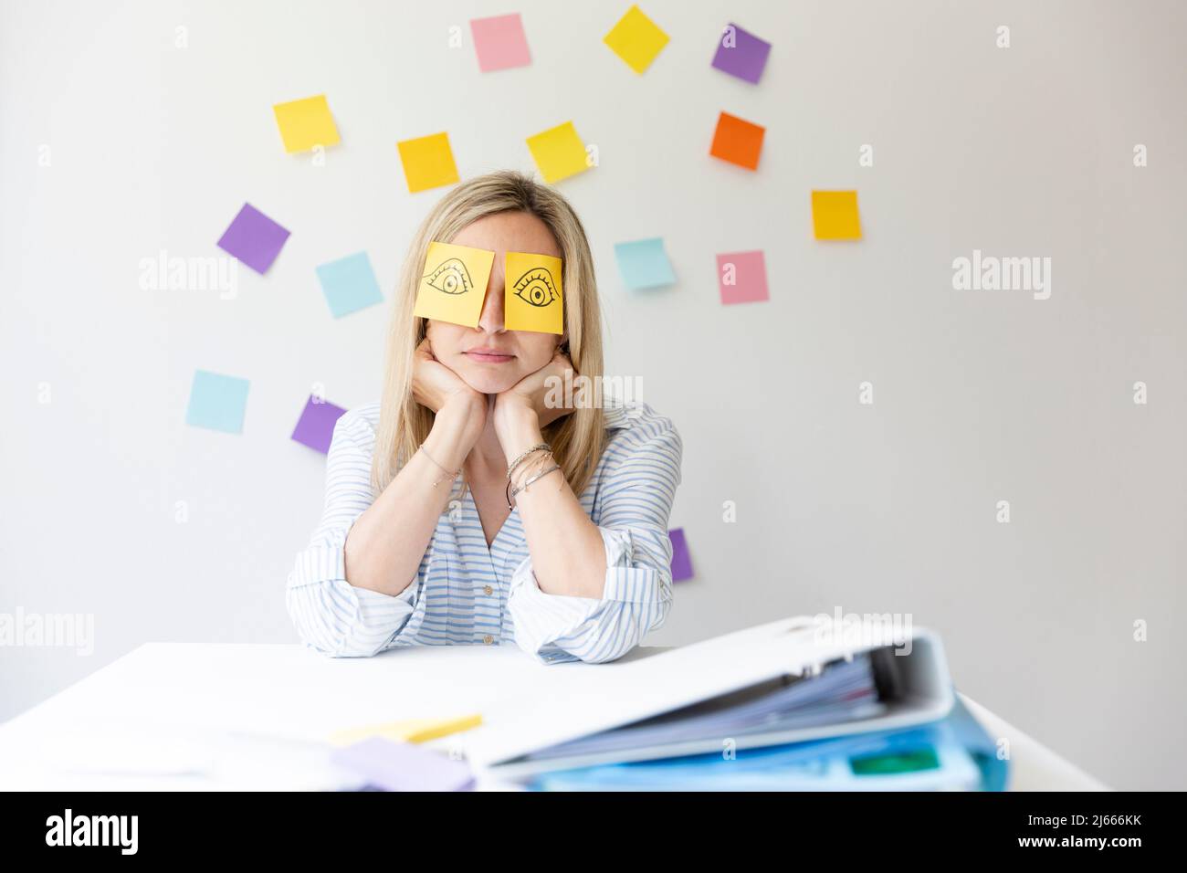 Business woman sits in bright modern office behind her desk on which ...