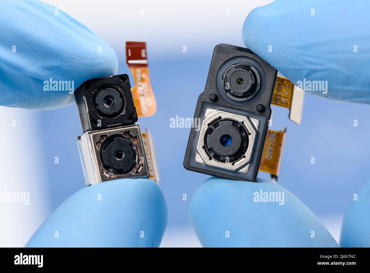 Smartphone single and dual camera modules in scientist hands. Different ...
