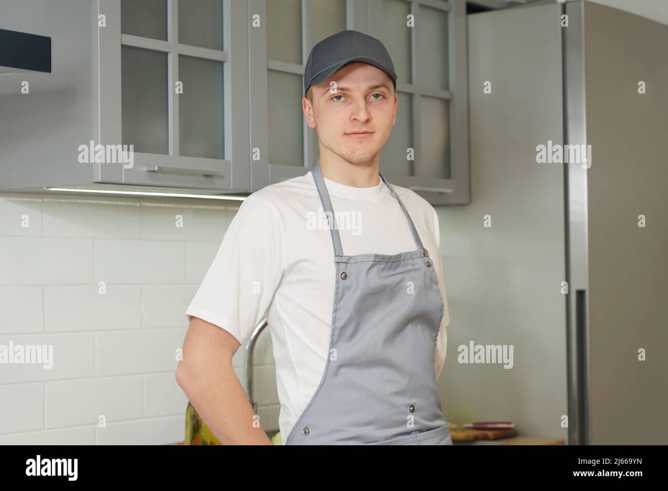 Portrait of a professional chef in the kitchen. He is wearing a white ...