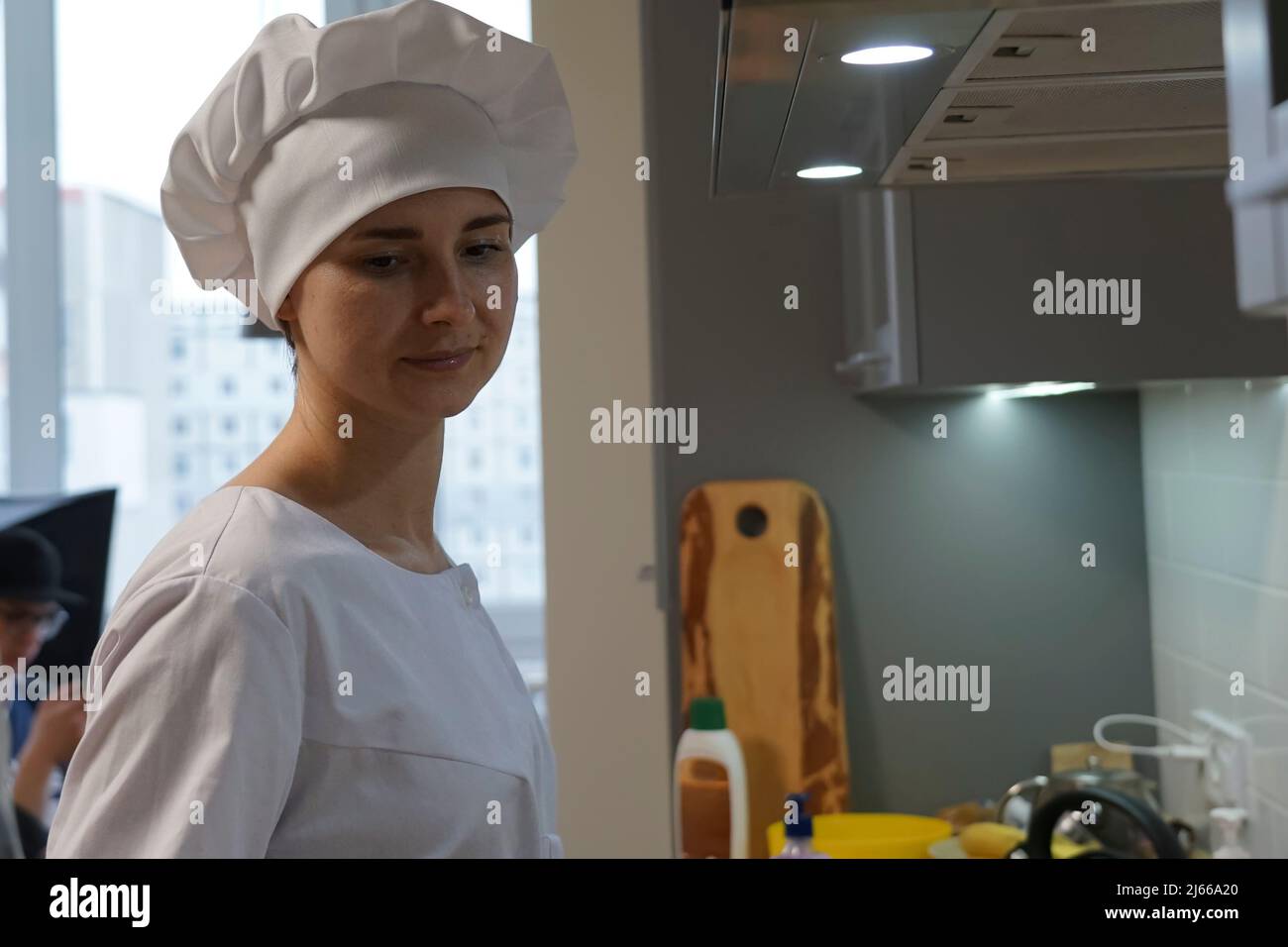 Chefs in the restaurant kitchen prepare food. The chef is dressed in a ...