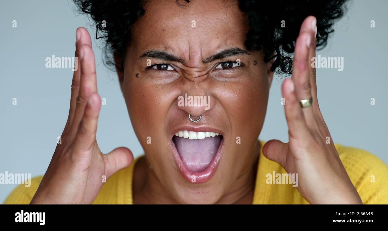 Mixed race young black hispanic woman yelling at camera Stock Photo - Alamy