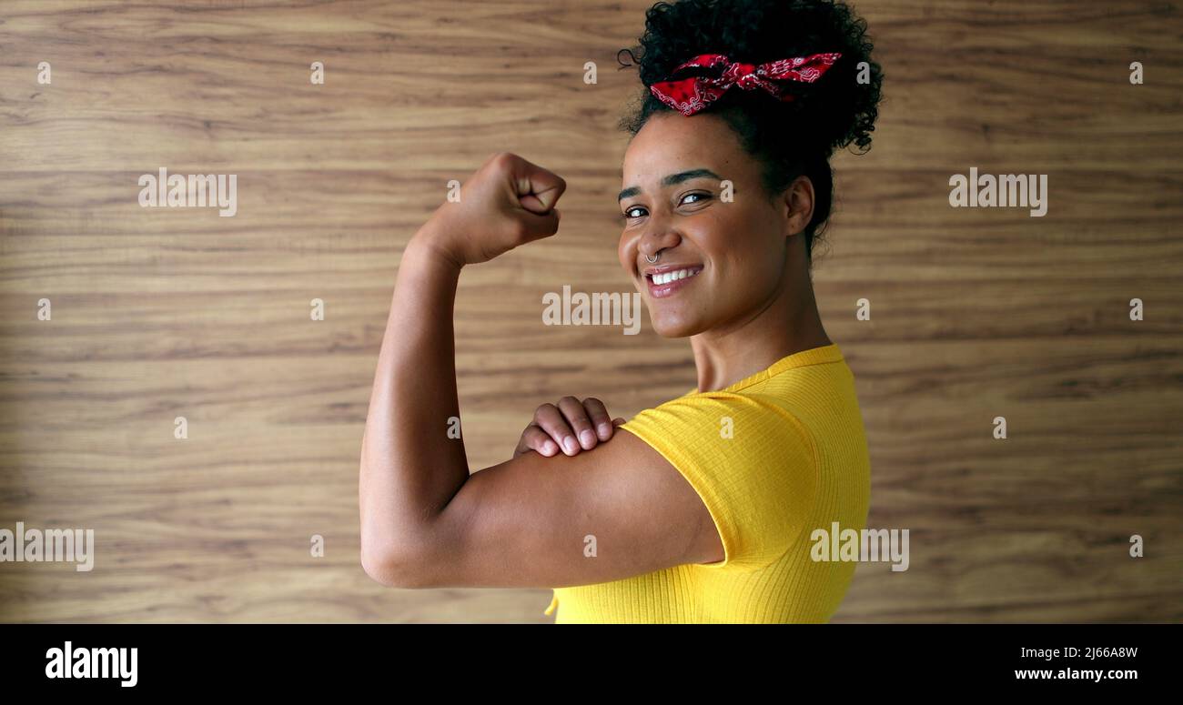 Proud young african american black woman shows muscle, Woman power ...
