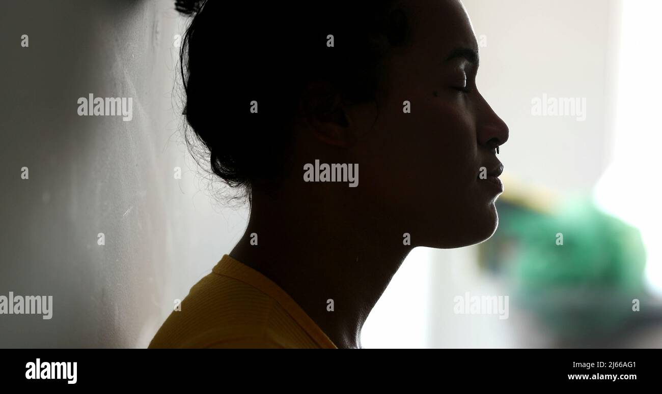 Spiritual black woman hands on chest leaning on wall in meditation ...