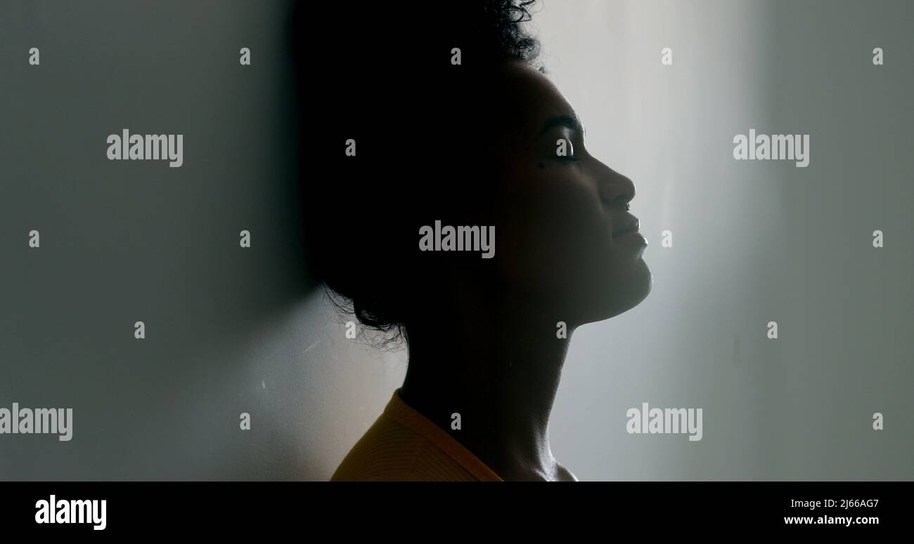Silhouette young black woman leaning on wall. Pensive African girl ...