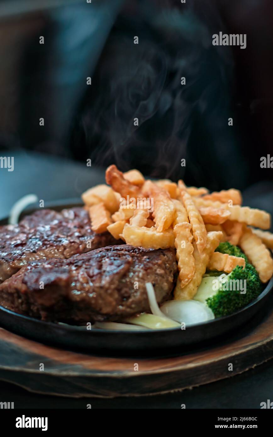 Teppanyaki steak and fries with smoke Stock Photo - Alamy