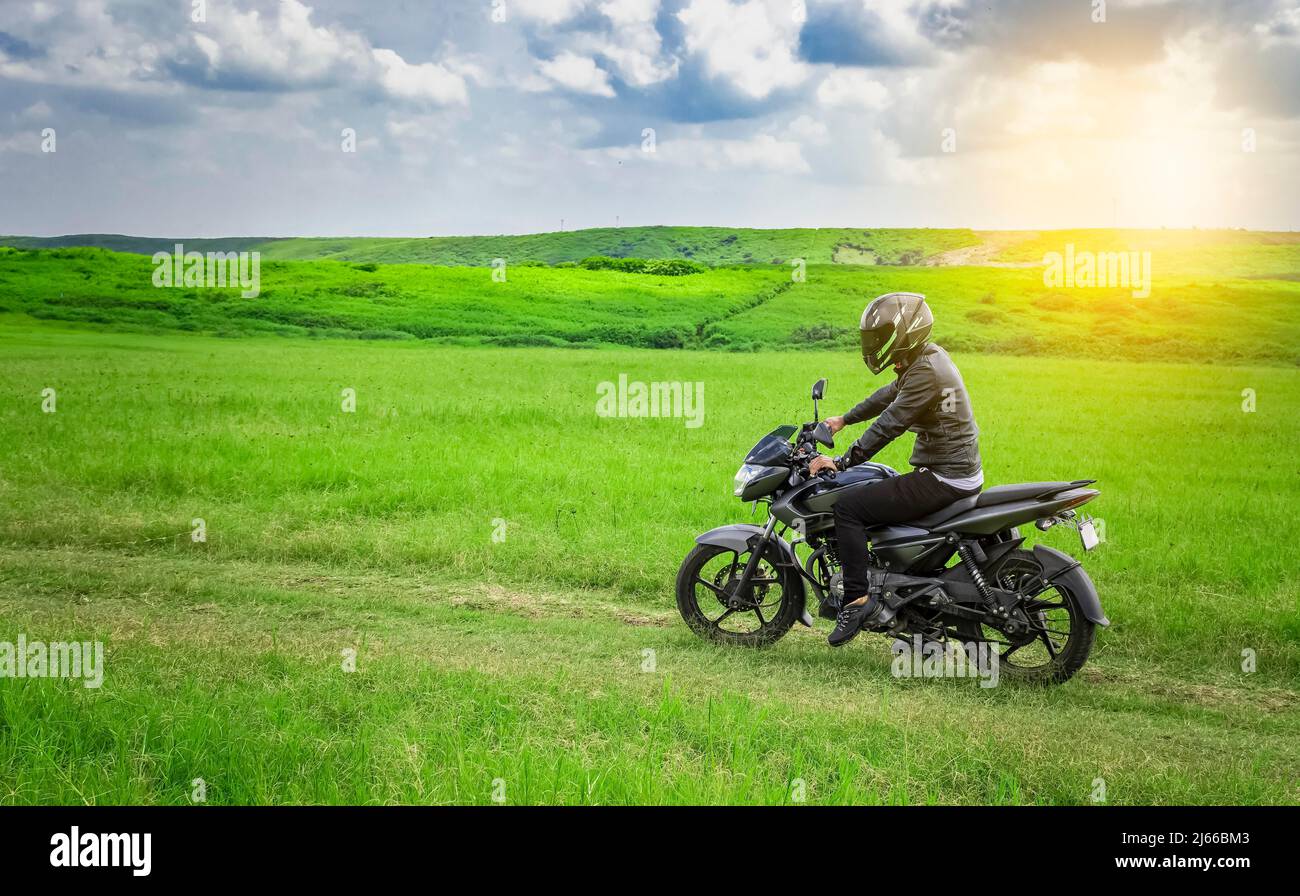 Biker man on a country road, young man on his motorcycle traveling ...