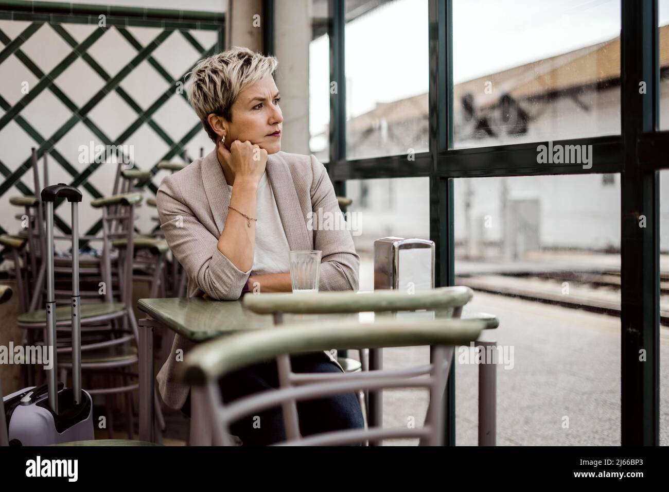 Sad thinking travelling woman waiting in a cafe at train station Stock ...