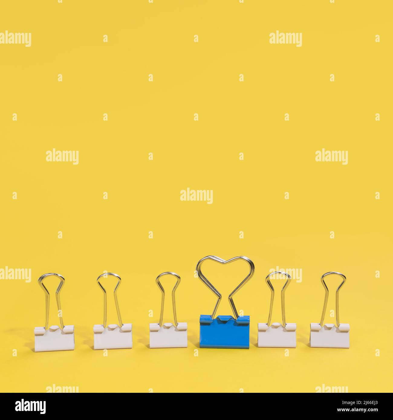 Arrangement paper clips with one blue paper clip Stock Photo - Alamy