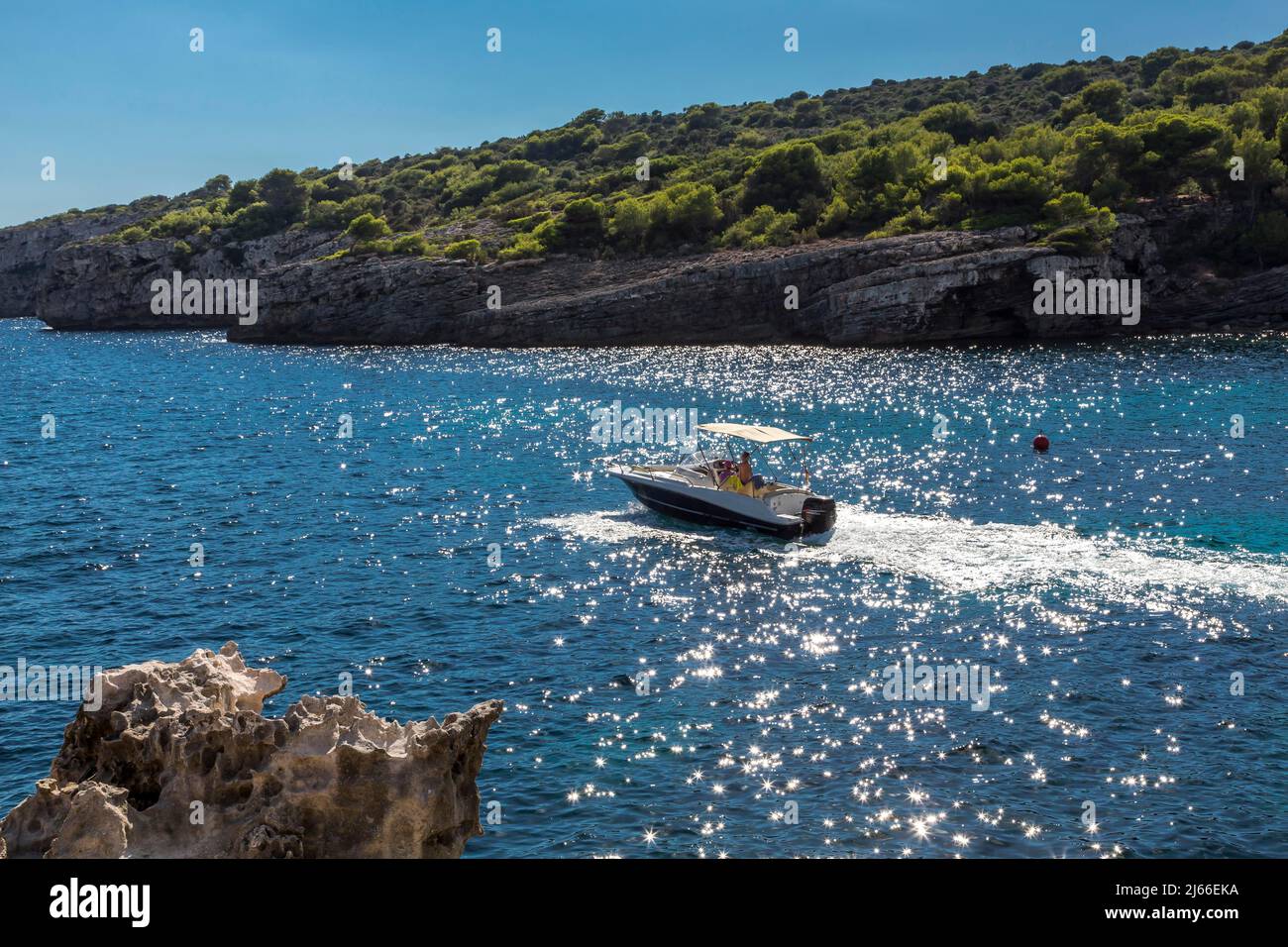 Yacht im glitzerden Wasser, Cala Turqueta, Ciutadella, Menorca ...