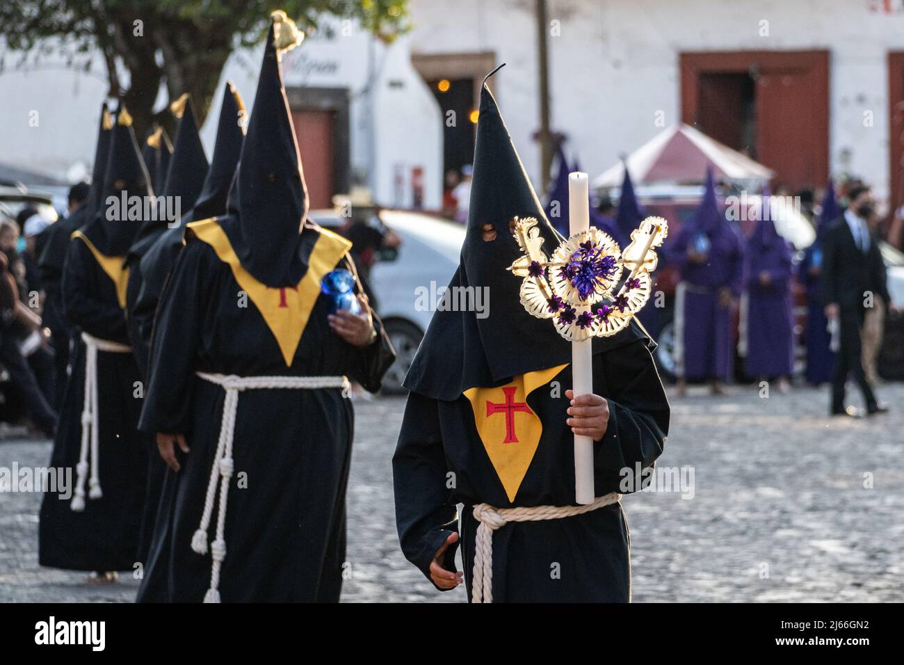Roman Catholic hooded penitents wearing traditional capirotes, hold a ...