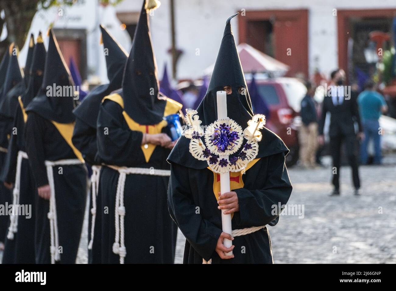 Roman Catholic hooded penitents wearing traditional capirotes, hold a ...