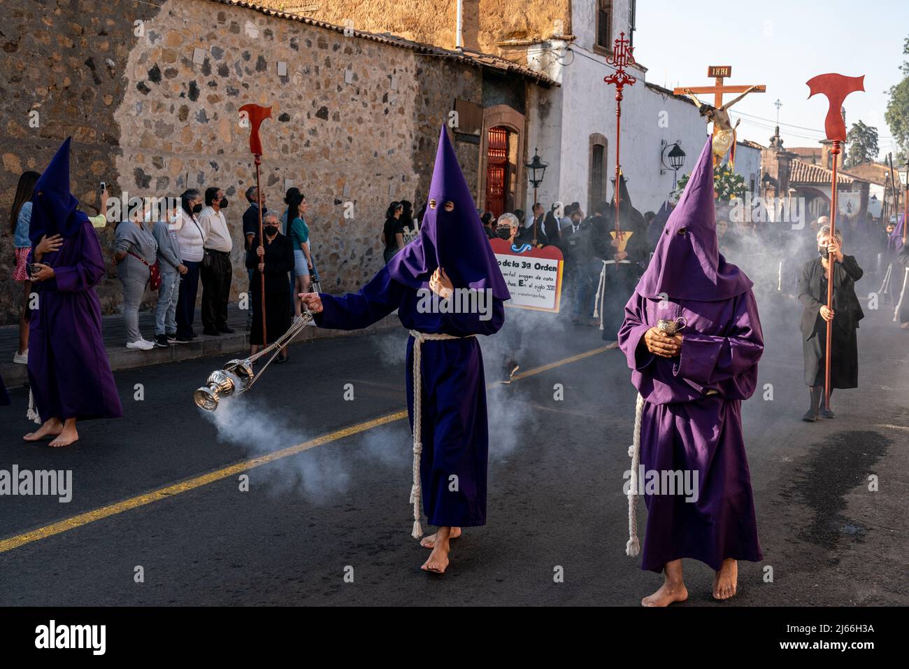 Roman Catholic hooded penitents wearing traditional capirotes, hold a ...