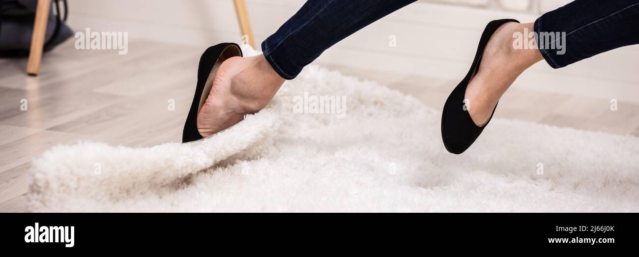Low Section Of Woman Stumble In A Carpet Stock Photo - Alamy