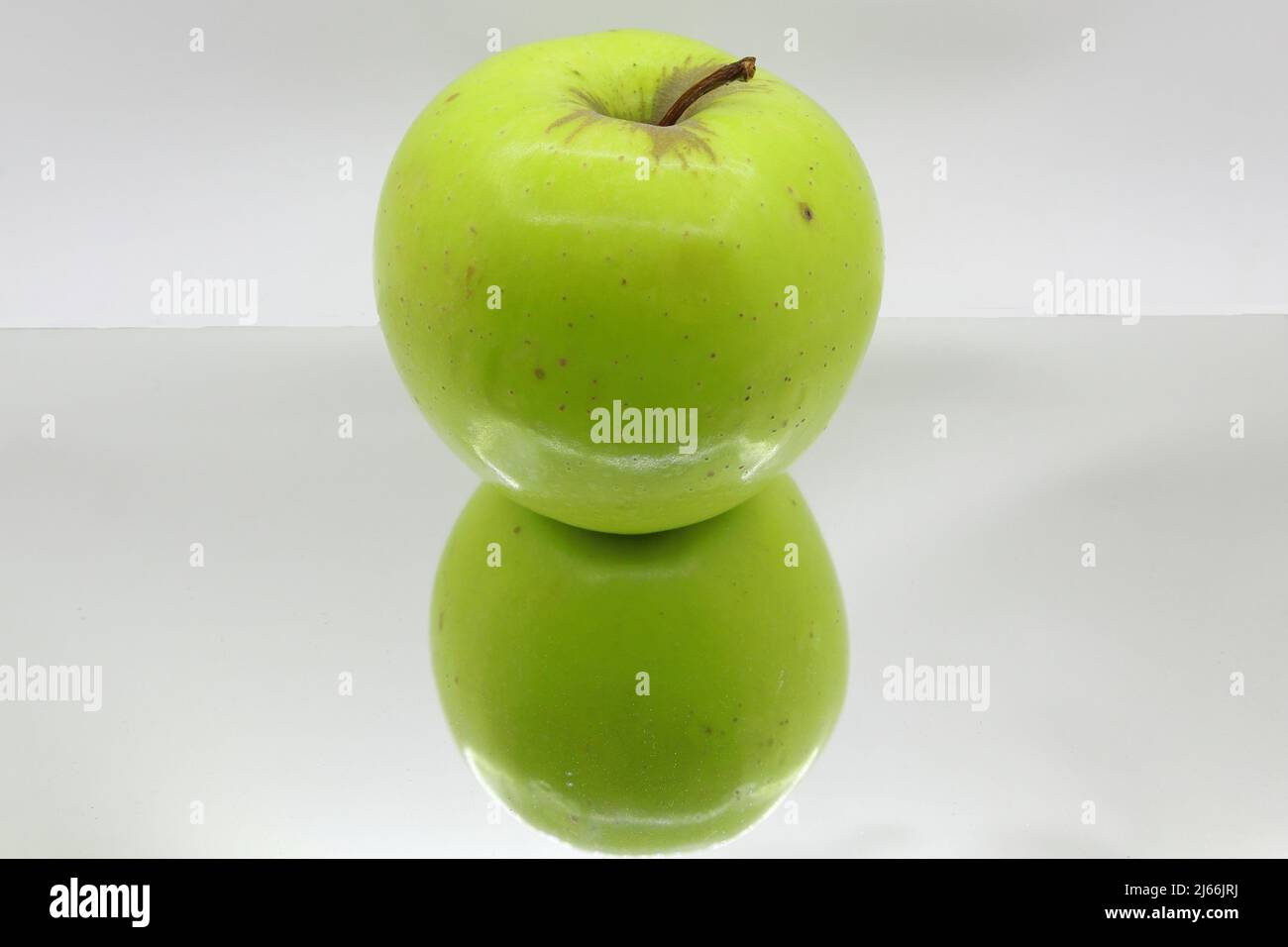 Green apple with reflection on white background Stock Photo - Alamy