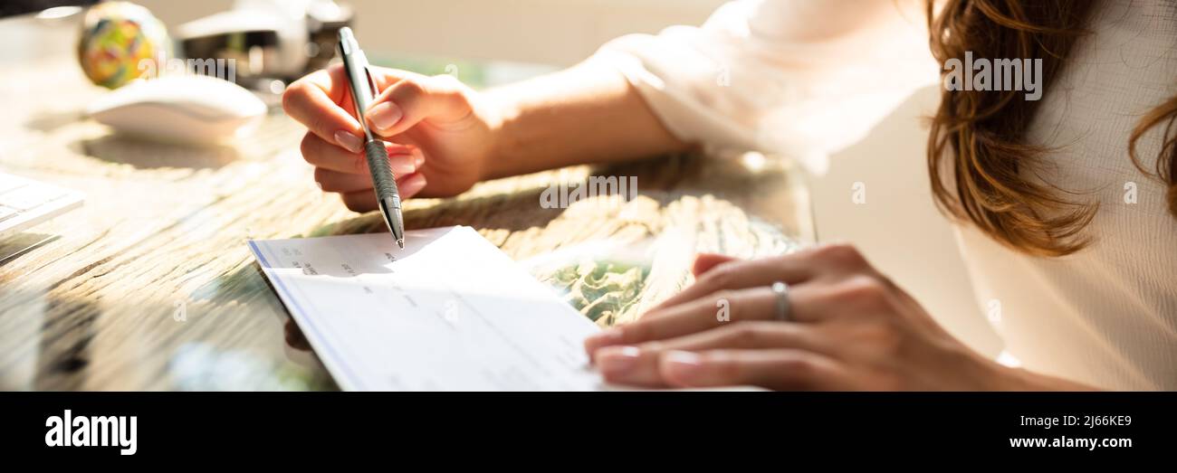 Hand signing check hi-res stock photography and images - Alamy