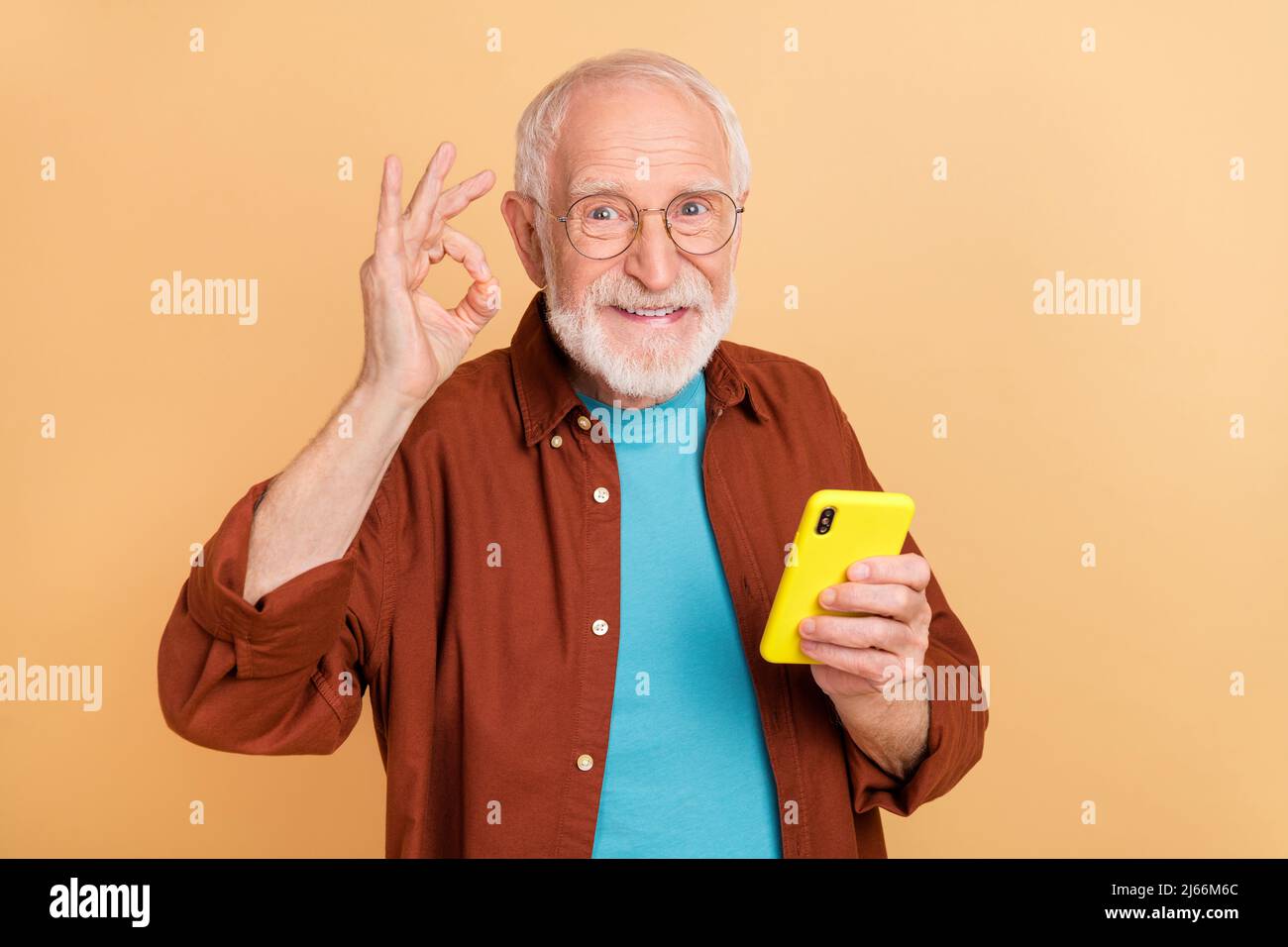 Photo of friendly grandpa use smartphone showing okay symbol recommend ...