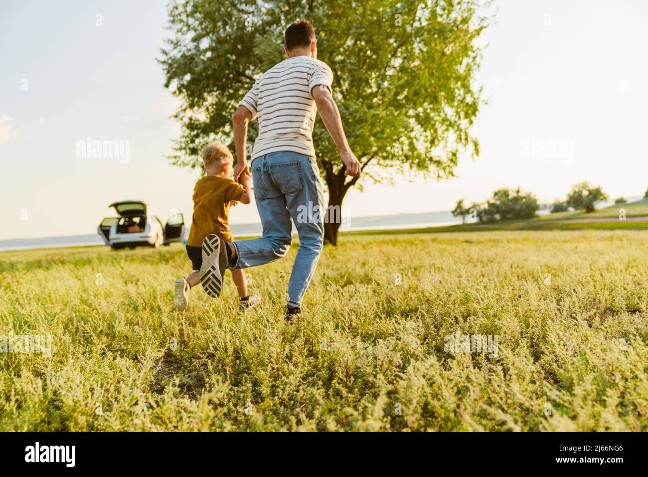 Young white father with his little son holding hands while running ...