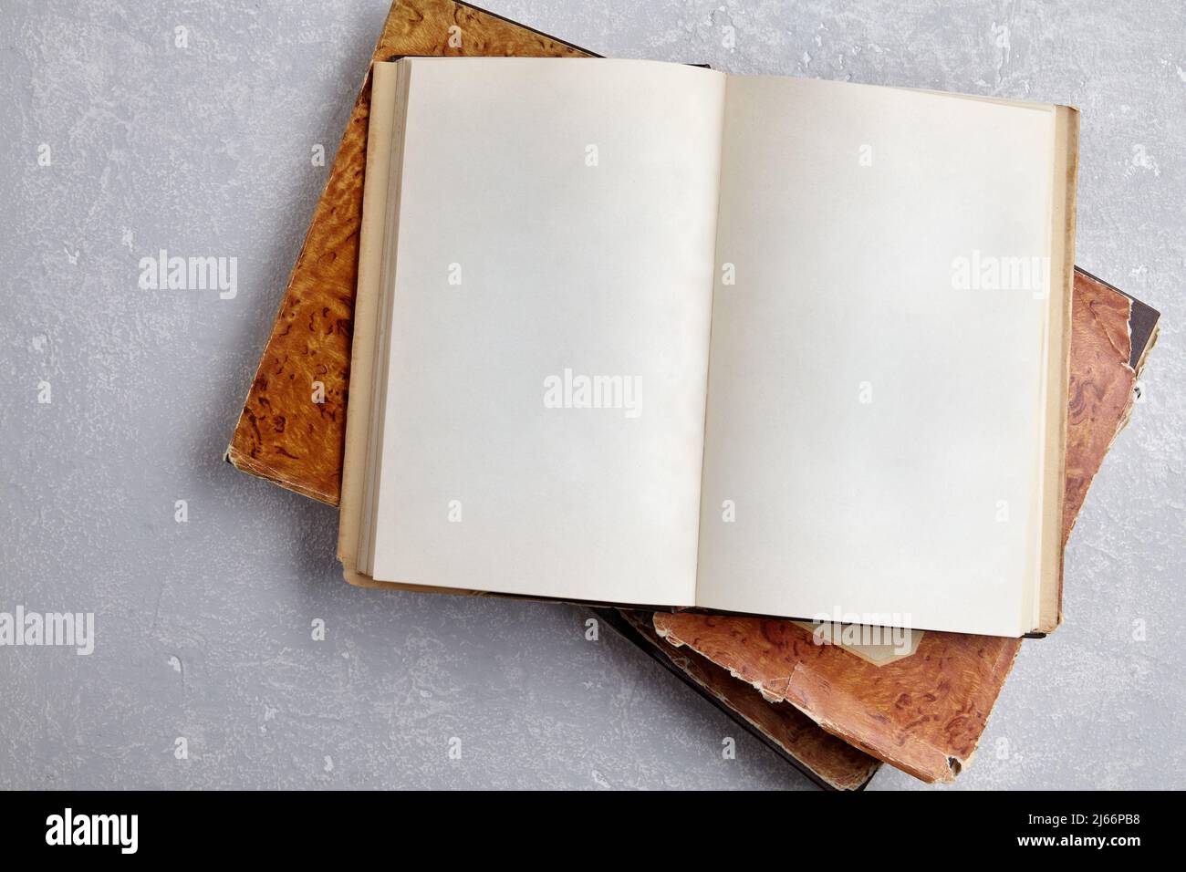 Open vintage book in a super cover on a stack of old dilapidated books ...