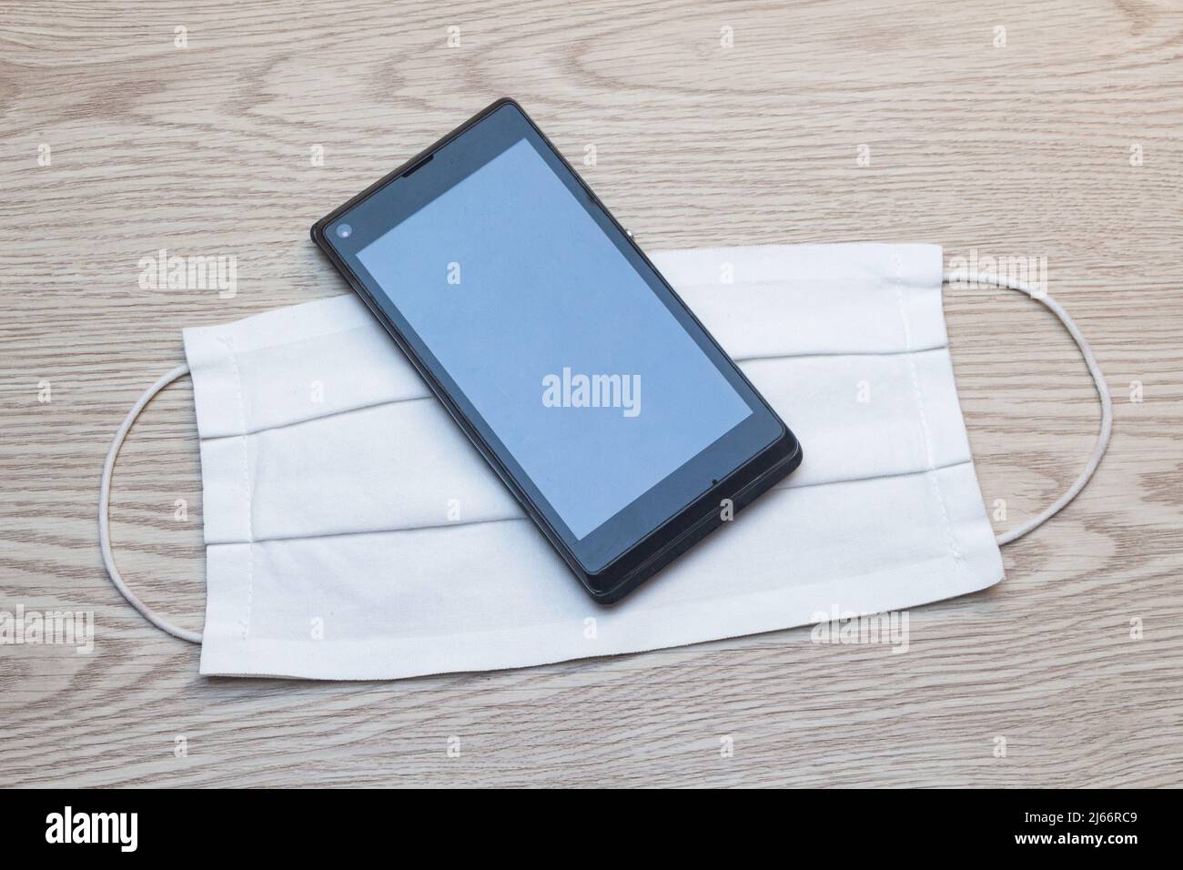 Face mask made in white fabric and mobile phone Stock Photo - Alamy