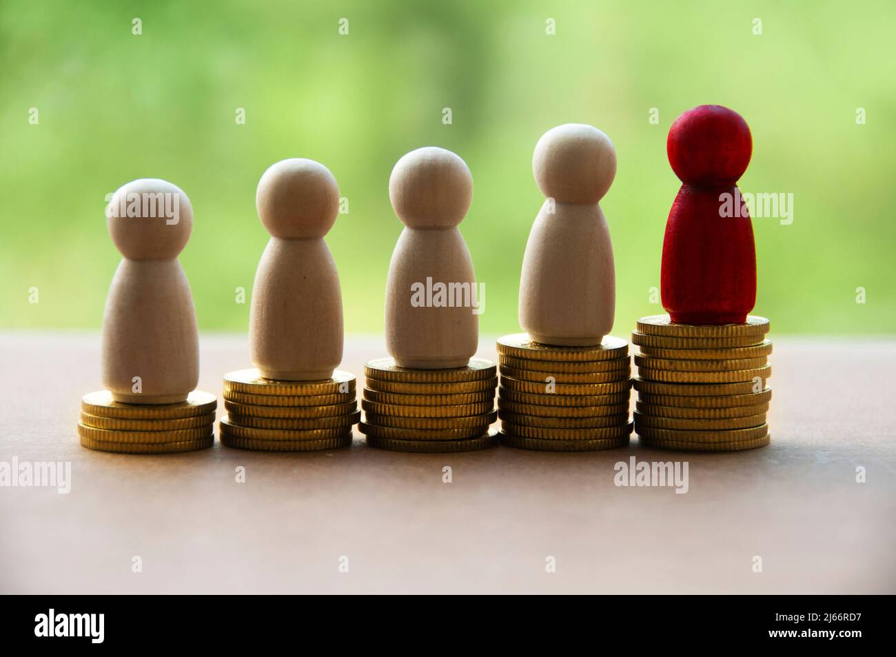 Wooden dolls standing on stack of gold coins. Copy space Stock Photo ...