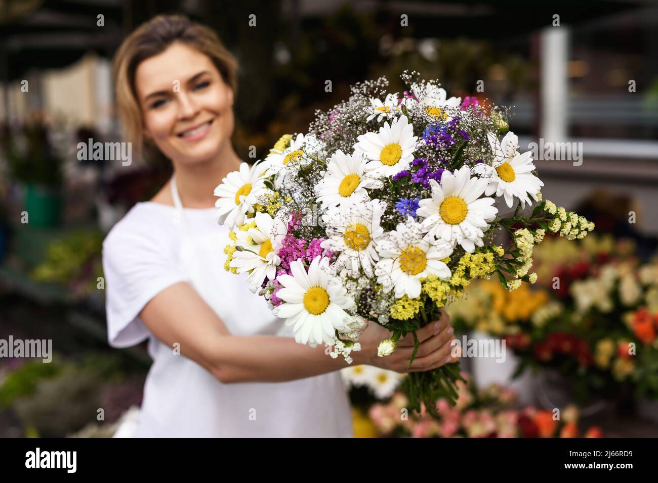 Woman florist with a bouquet of wildflowers in her little flower shop ...