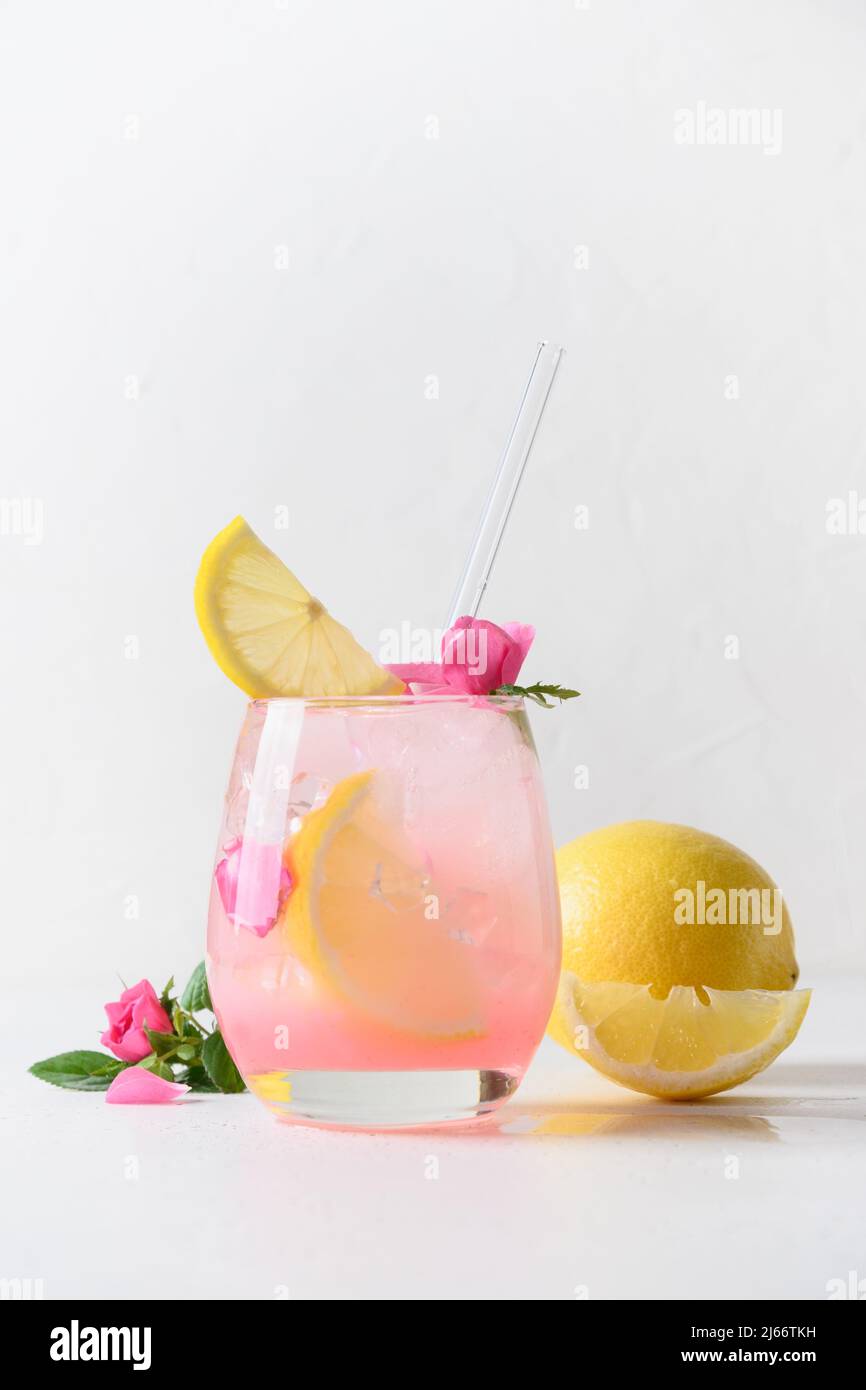 Pink alcoholic rose beverage or lemonade, cocktail with rose flowers ...