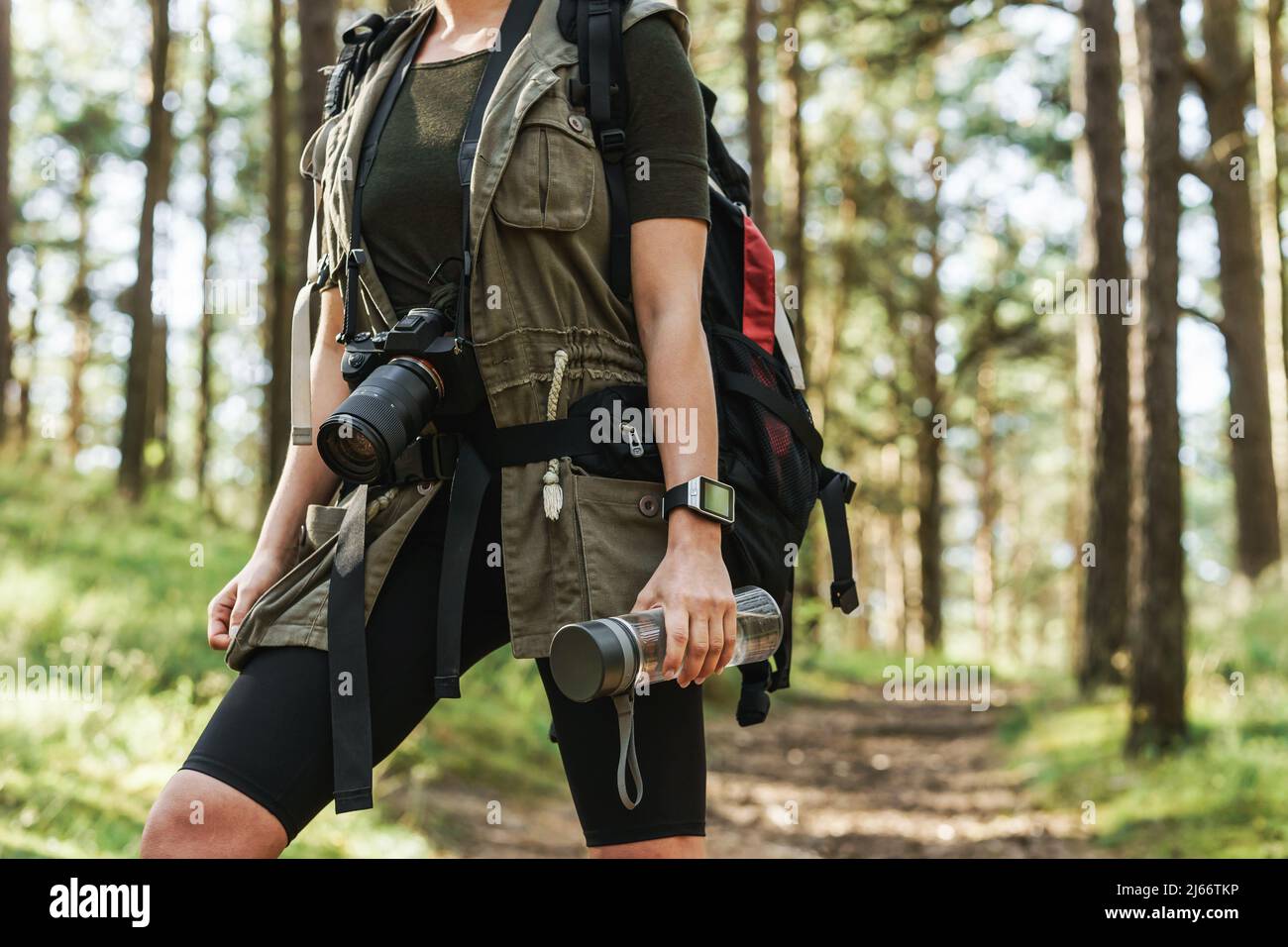Female hiker with modern mirrorless camera in green forest Stock Photo ...