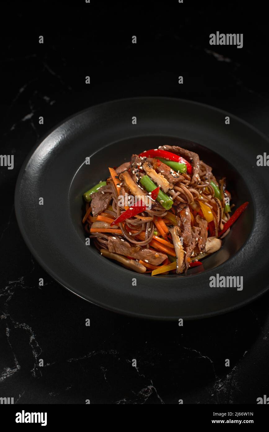 Top view, Soba beef and vegetables, Buckwheat noodles on a dark stone ...