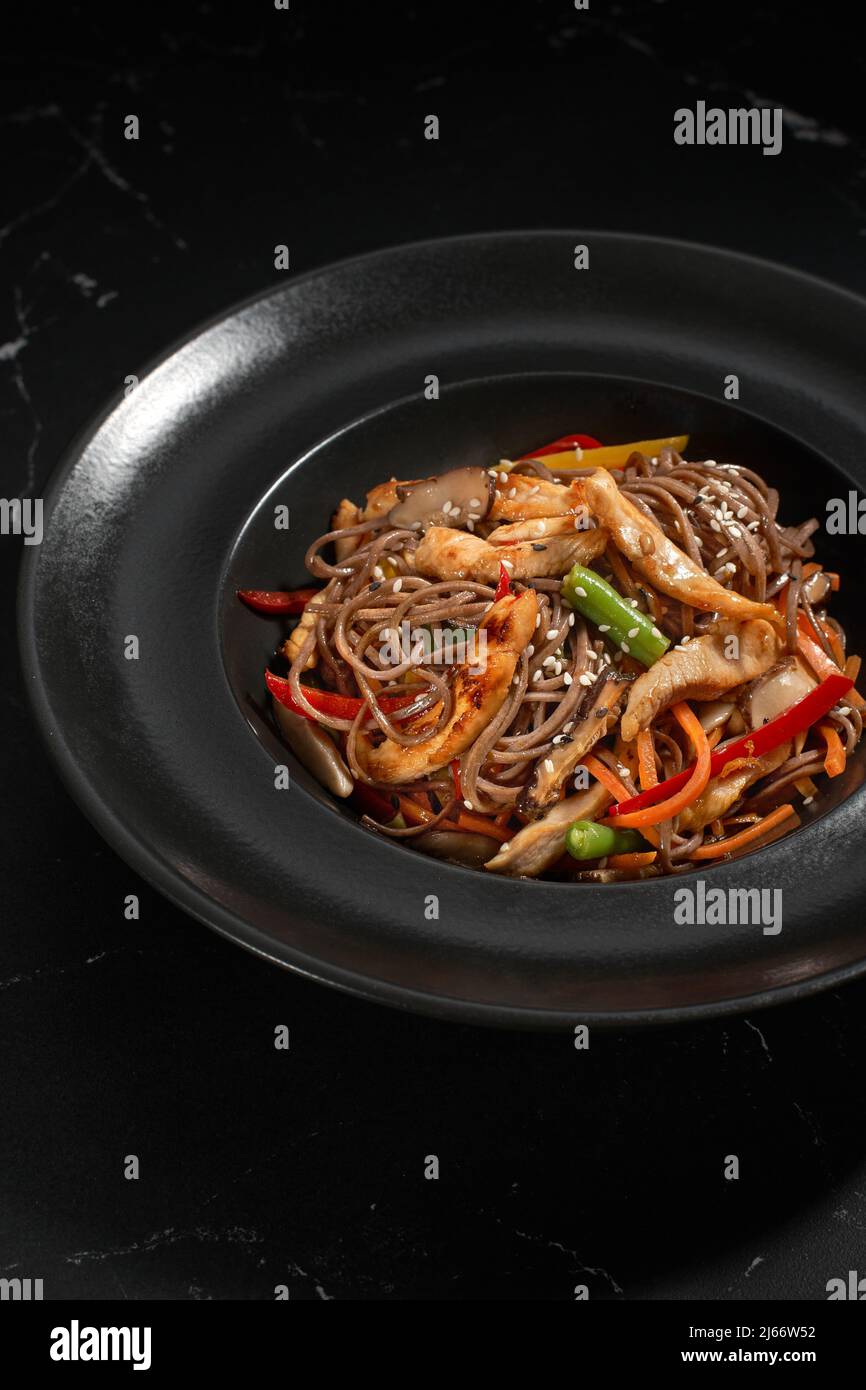 Top view, Soba Chicken and vegetables, Buckwheat noodles on a dark ...