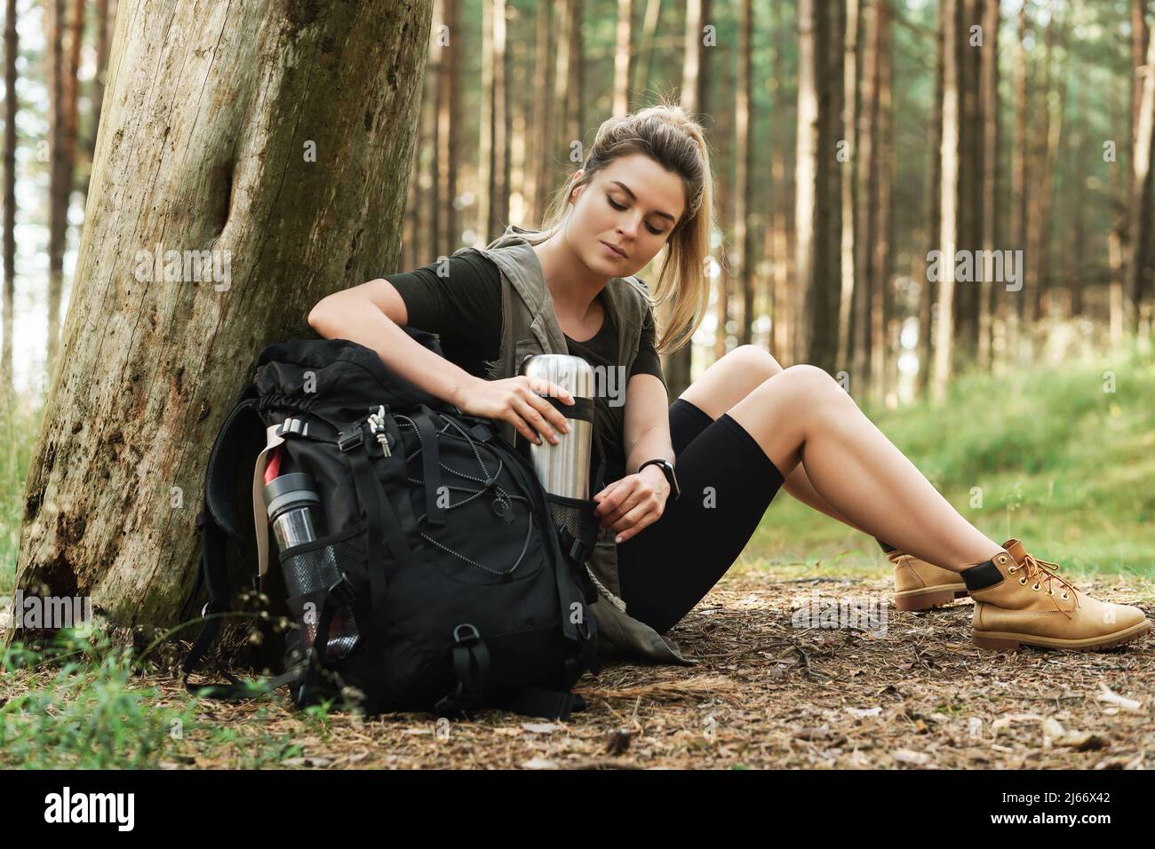Female hiker during small halt sitting in green forest Stock Photo - Alamy