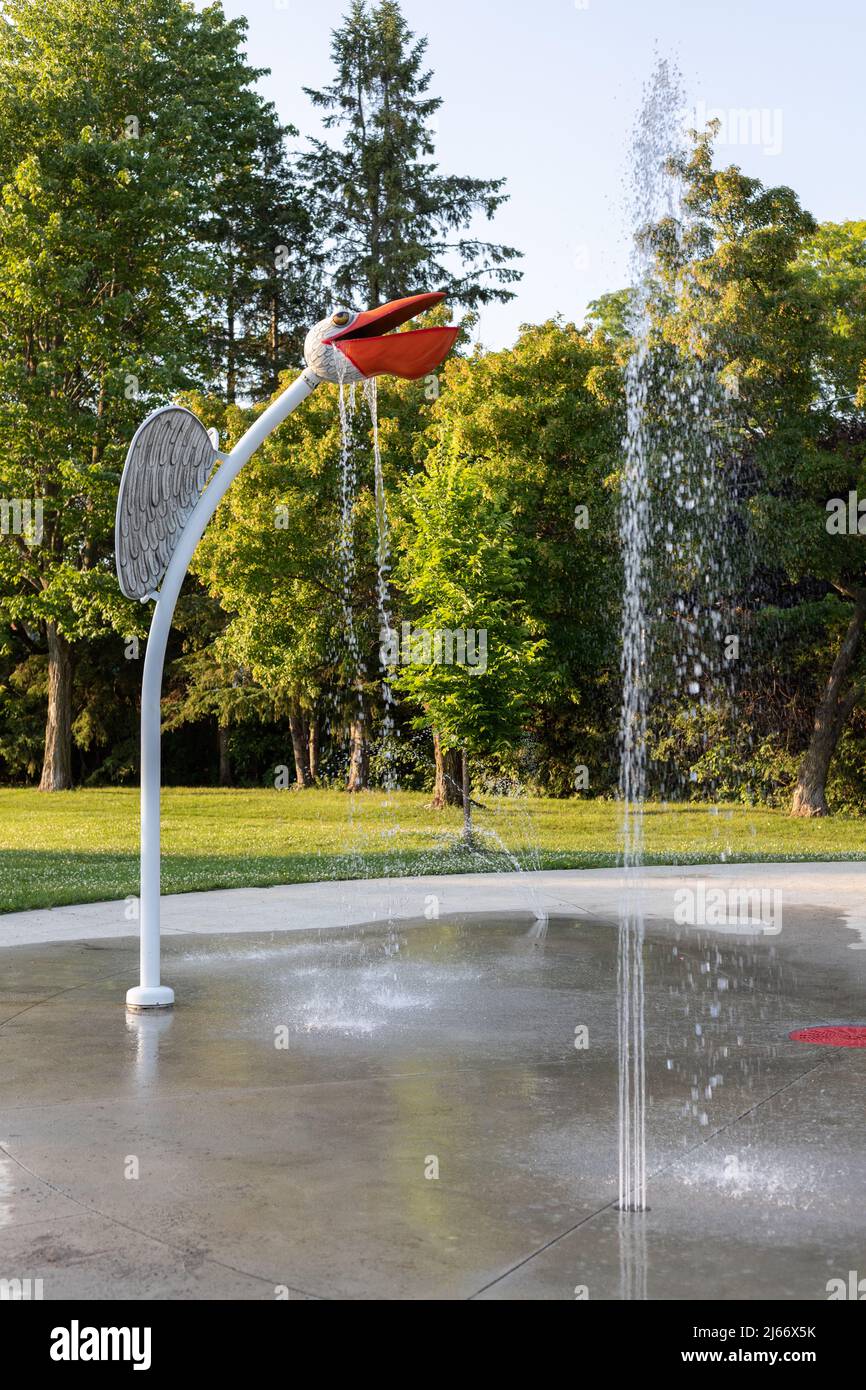 Splash pad playground in public park in summer without people. Fountains with splashing water on ...