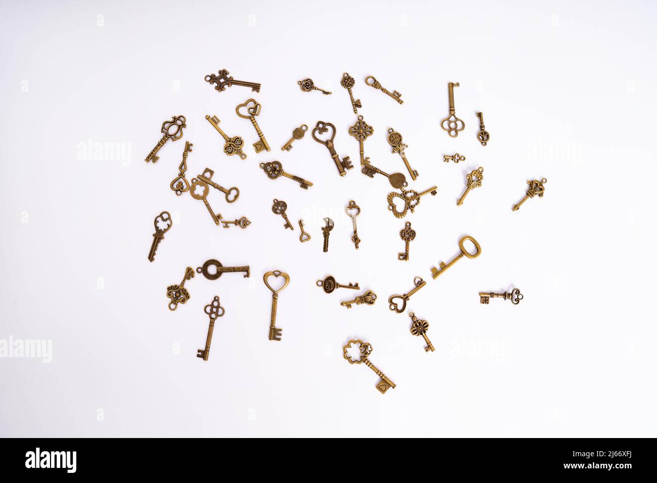 A pile of vintage golden skeleton keys isolated on white background ...