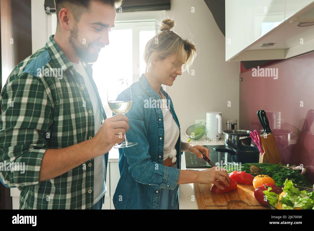 Happy couple cooking launch and drinking wine together in the kitchen ...