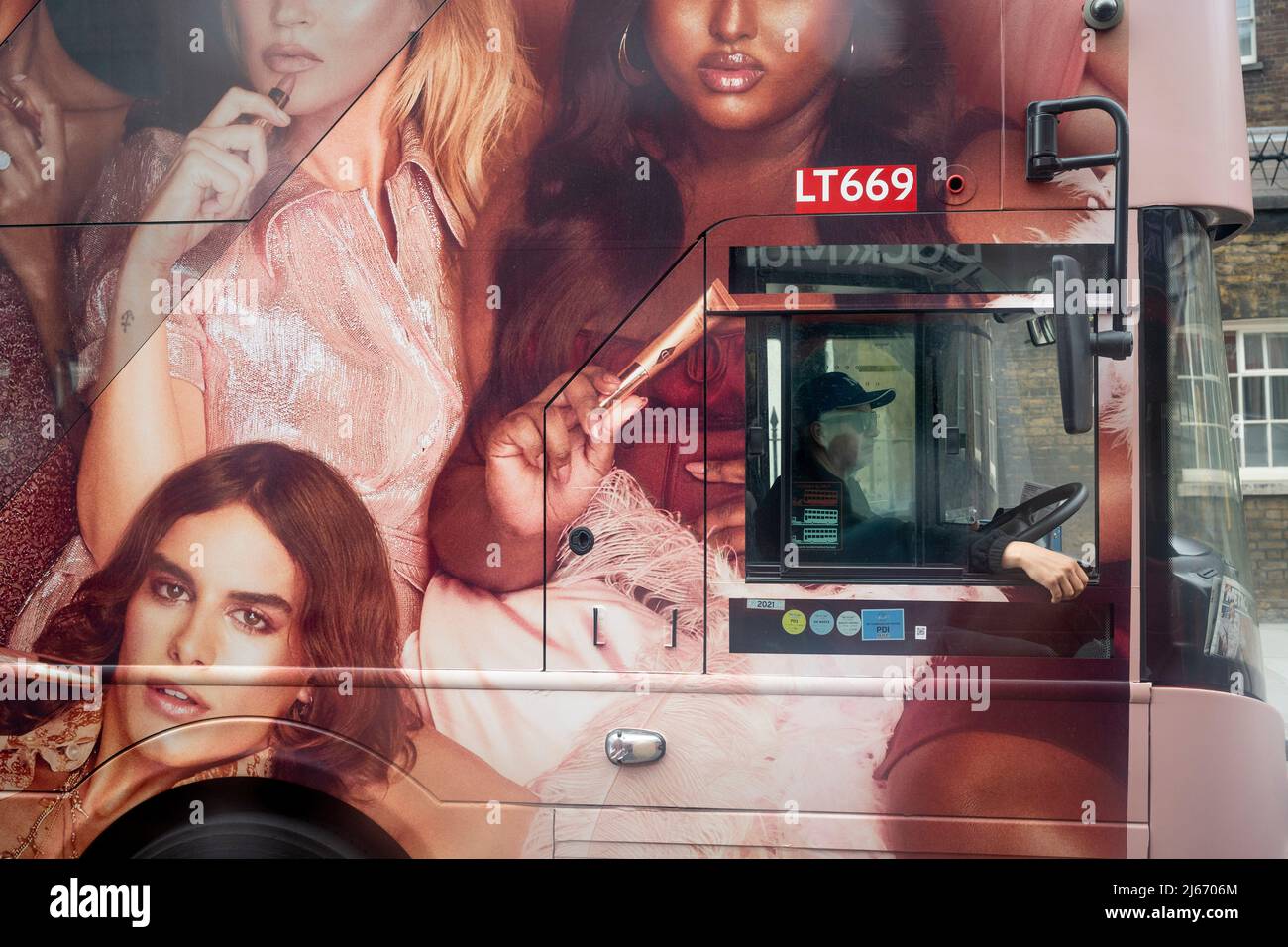 Surrounded by the advertising on the side of his bus, a bus driver ...