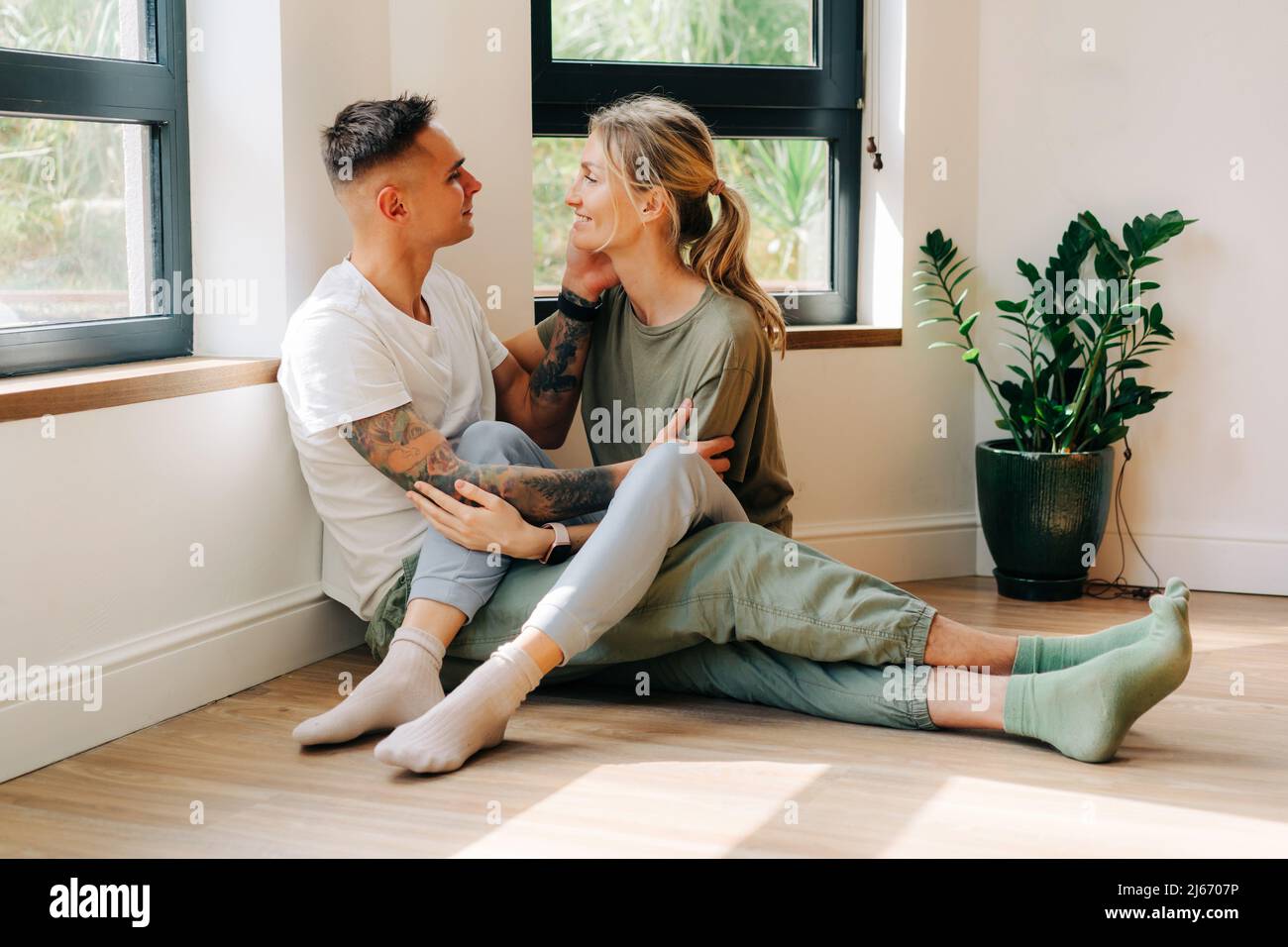 Young happy couple in their new apartment hugging while sitting on the floor on a date Stock ...