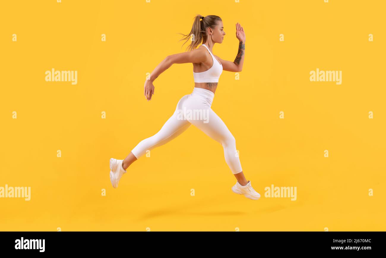 energetic sport girl runner running on yellow background Stock Photo ...