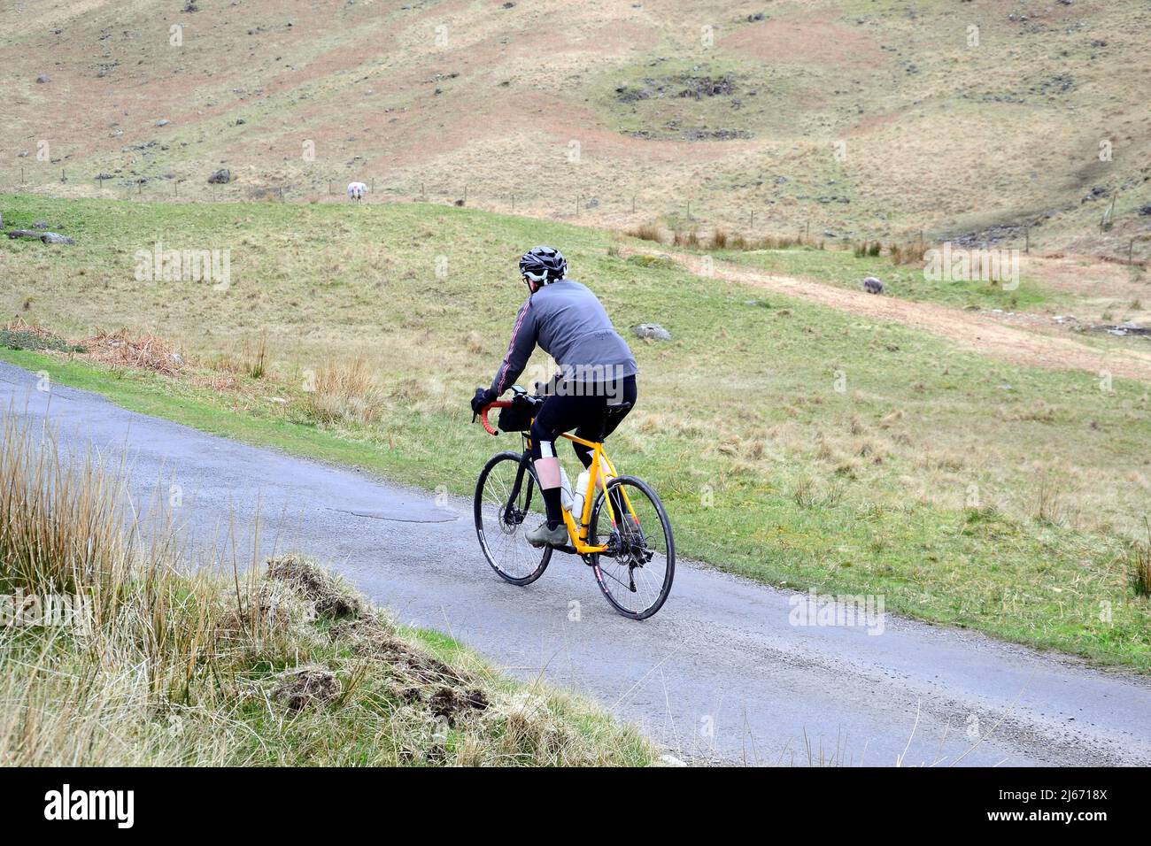 A cyclist starts to rides up Hardknott Pass, one of the steep Lakeland ...
