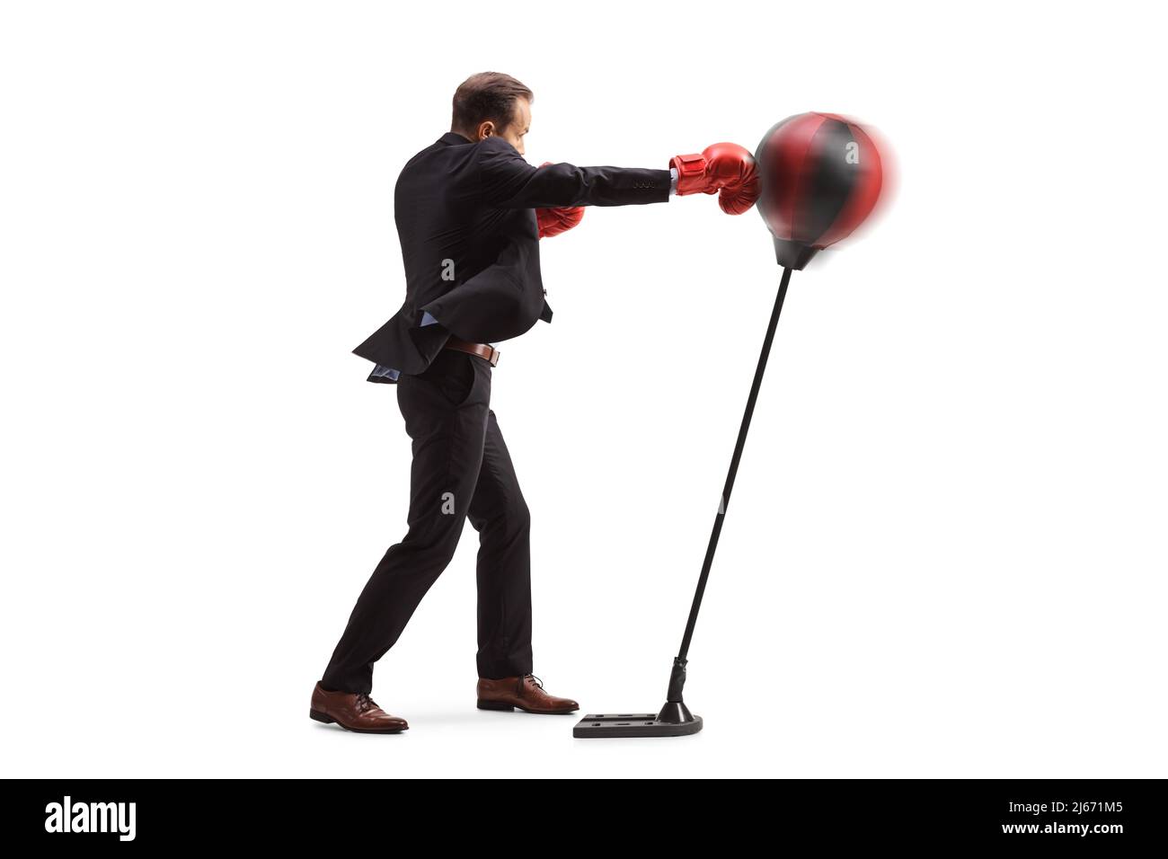 Full length profile shot of a businessman hitting a free stand punch ...