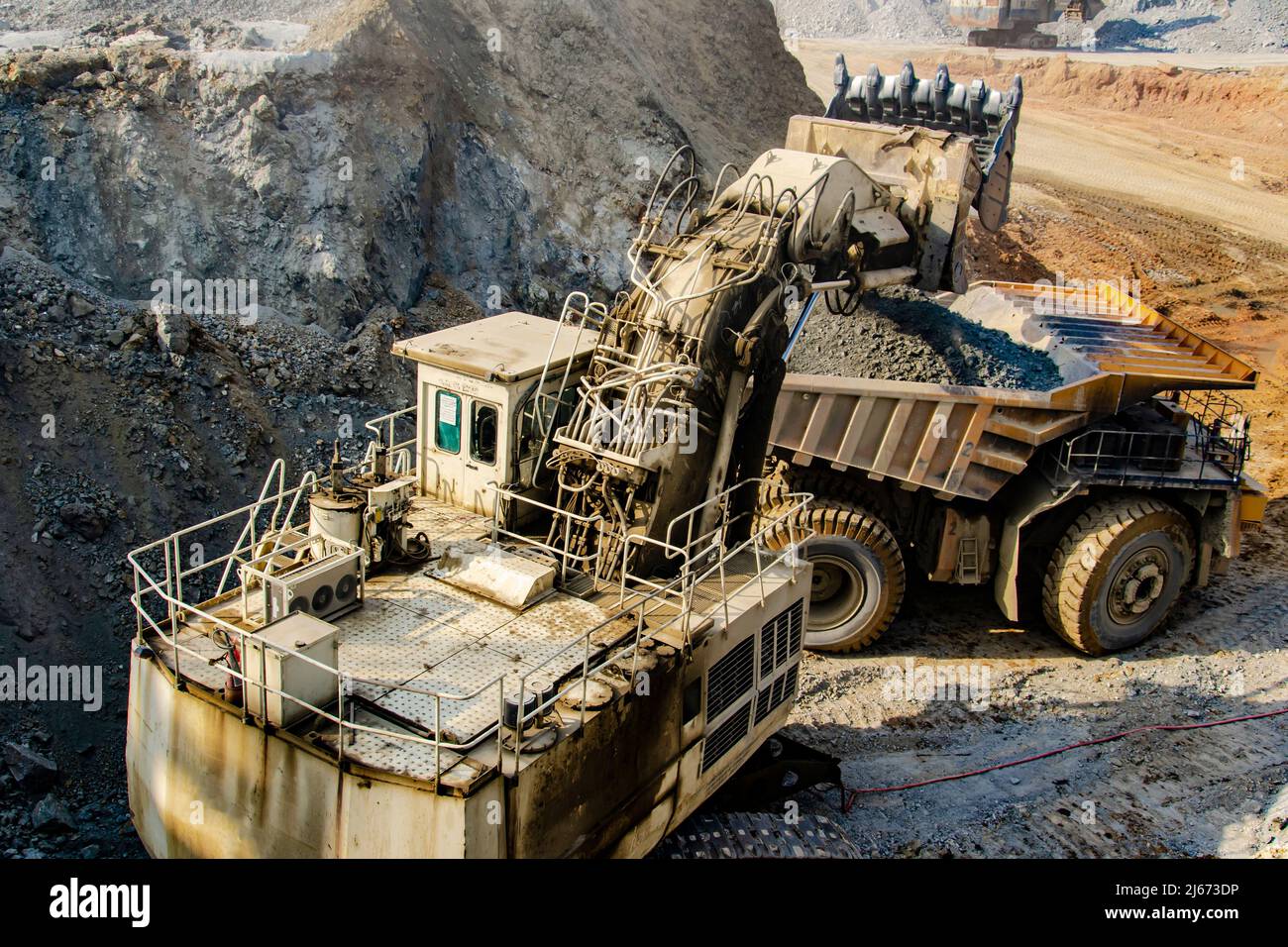 Excavator loading big dump truck in the open pit Stock Photo - Alamy