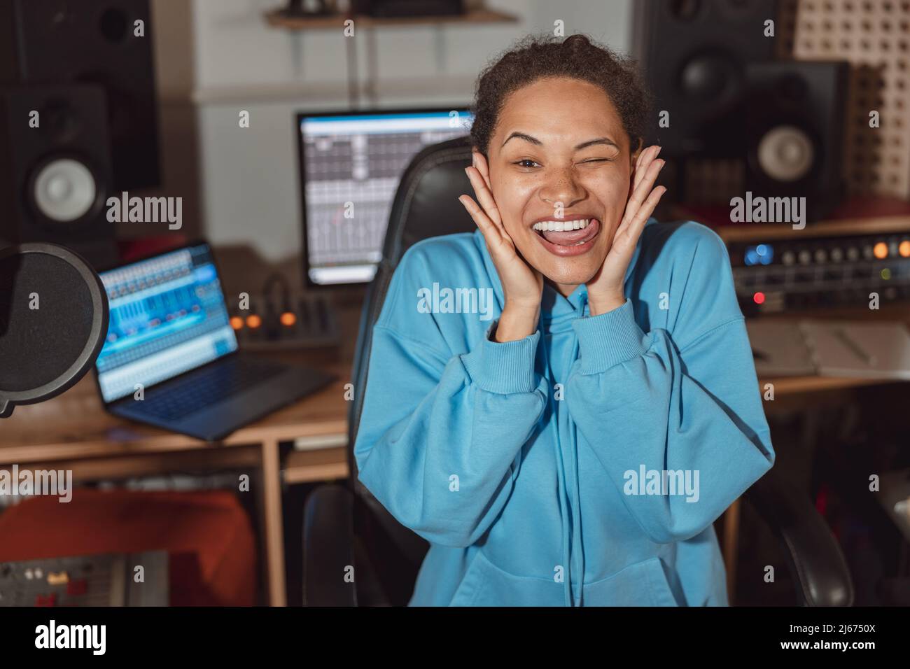 Funny cheerful African woman, sound engineer or radio presenter ...