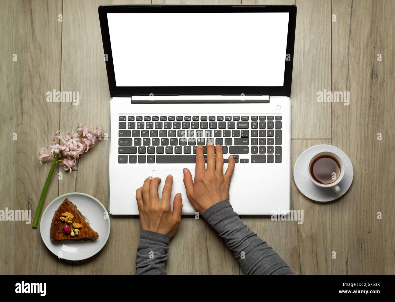 Top view of hands working on laptop with white screen with coffee at ...