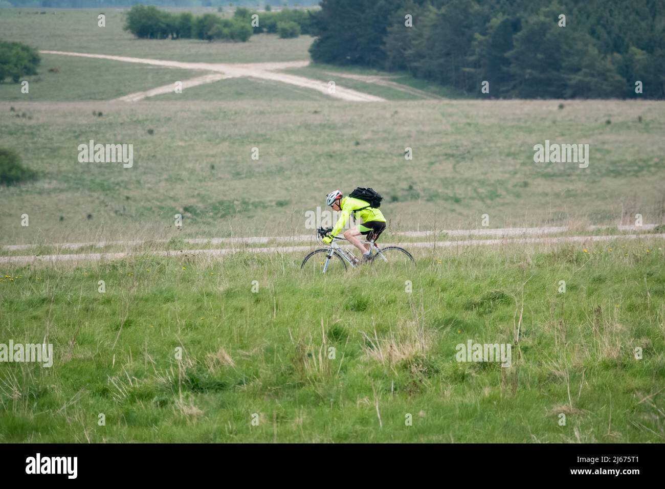 sports cyclist with a rucksack and high-vis yellow jacket riding on a ...