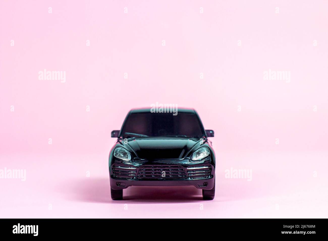 Small black car toy model front on light pink background Stock Photo ...