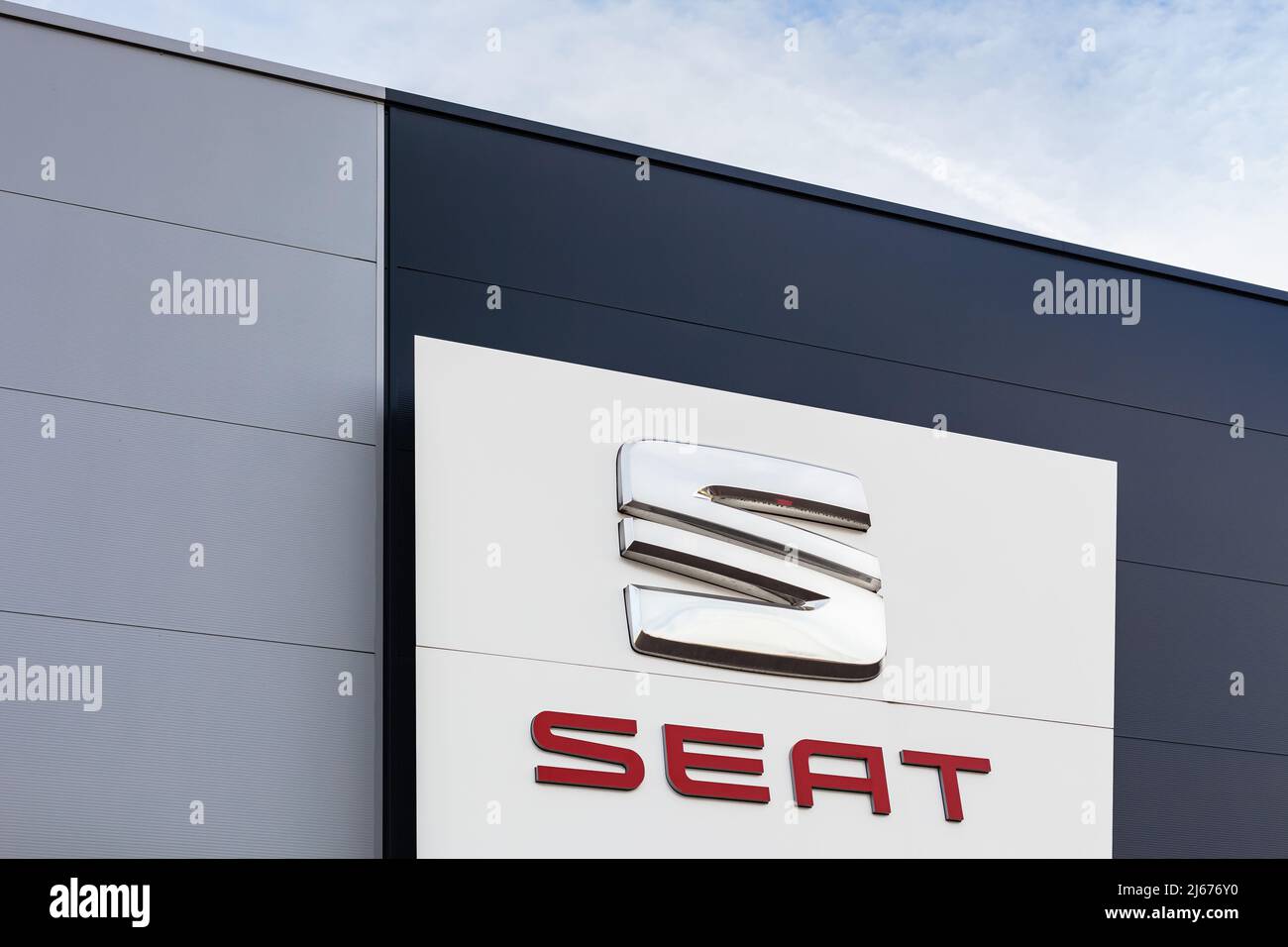 SEAT brand logo on bright blue sky background located on its dealer ...